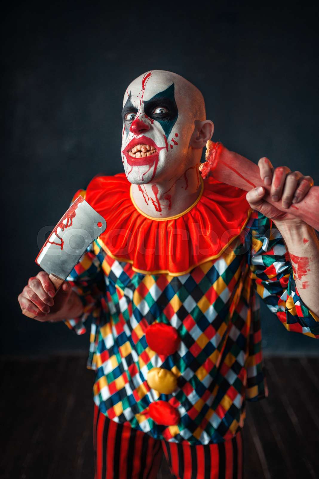Bloody clown with meat cleaver and baseball bat | Stock image | Colourbox