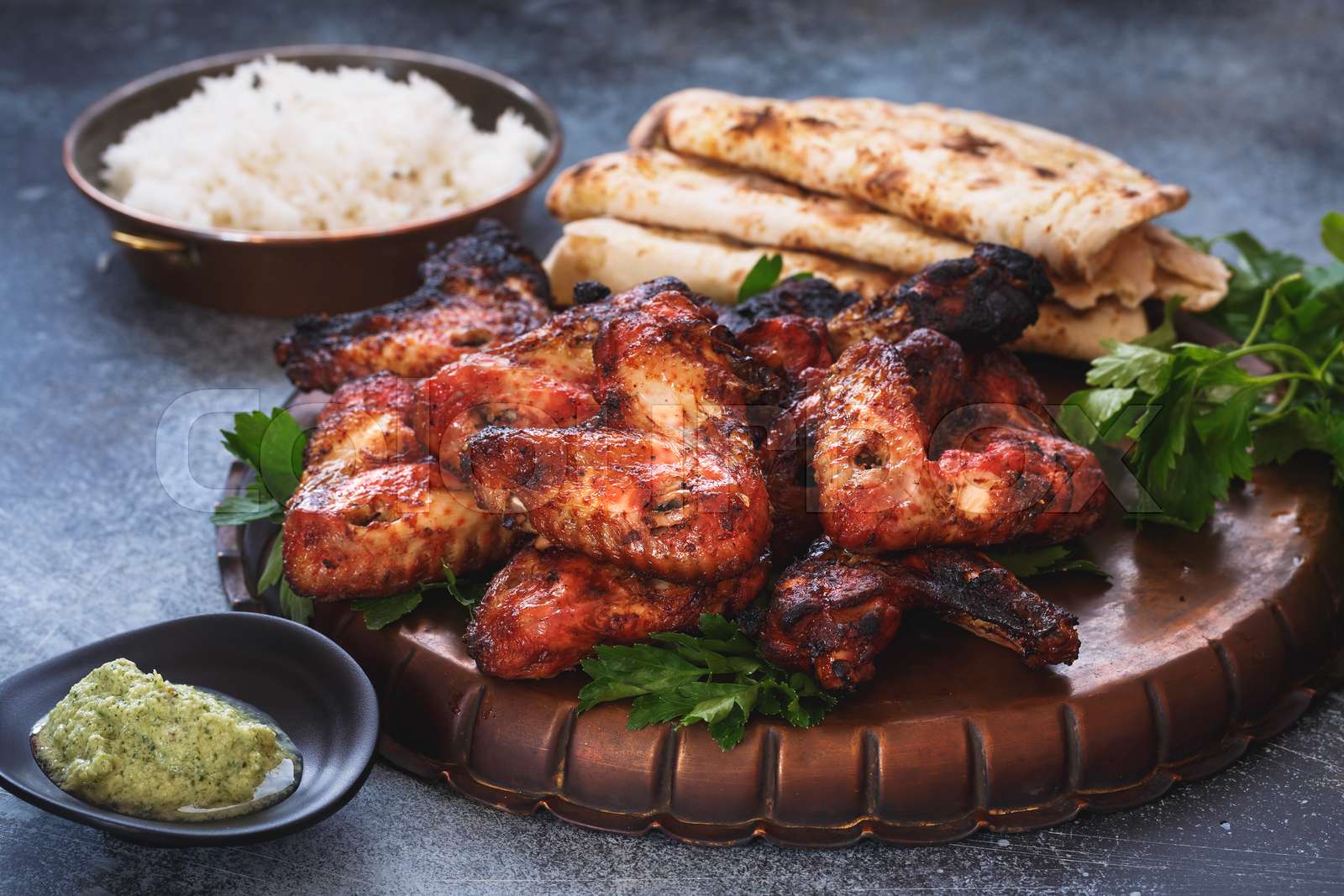 Indian tandoori chicken wings served with pilau rice and garlic naan ...