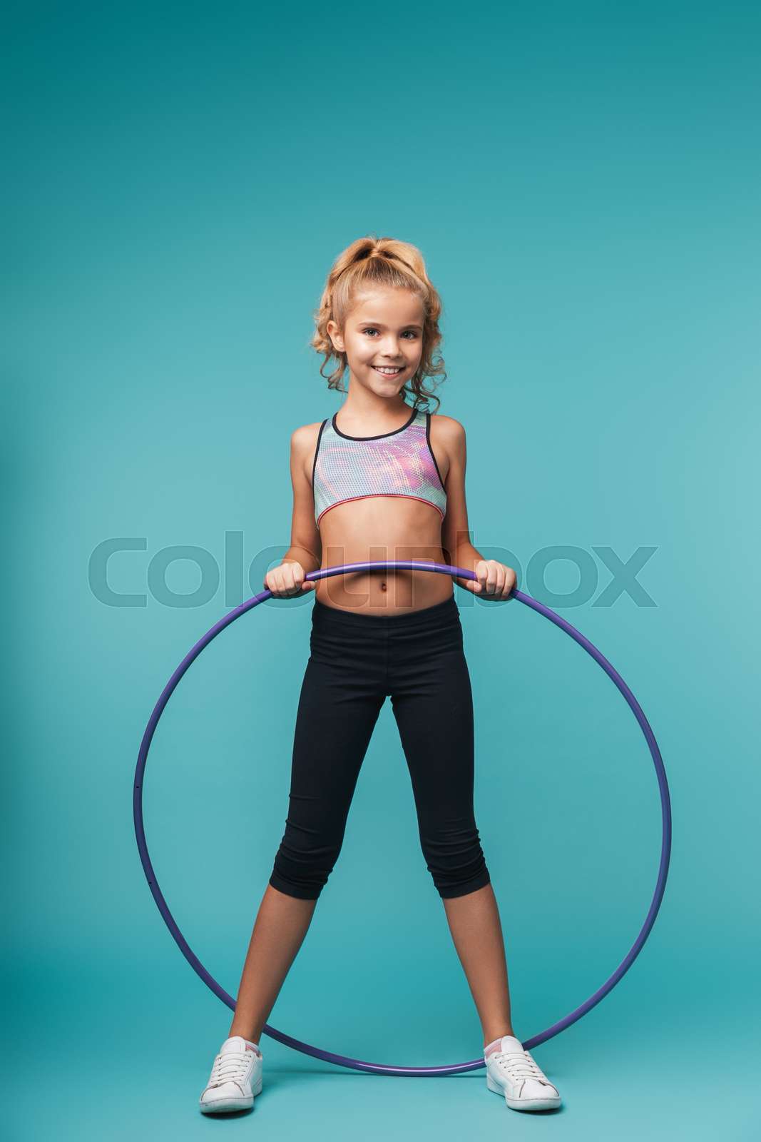 Cheerful little sports girl doing exercises with a hula hoop | Stock ...