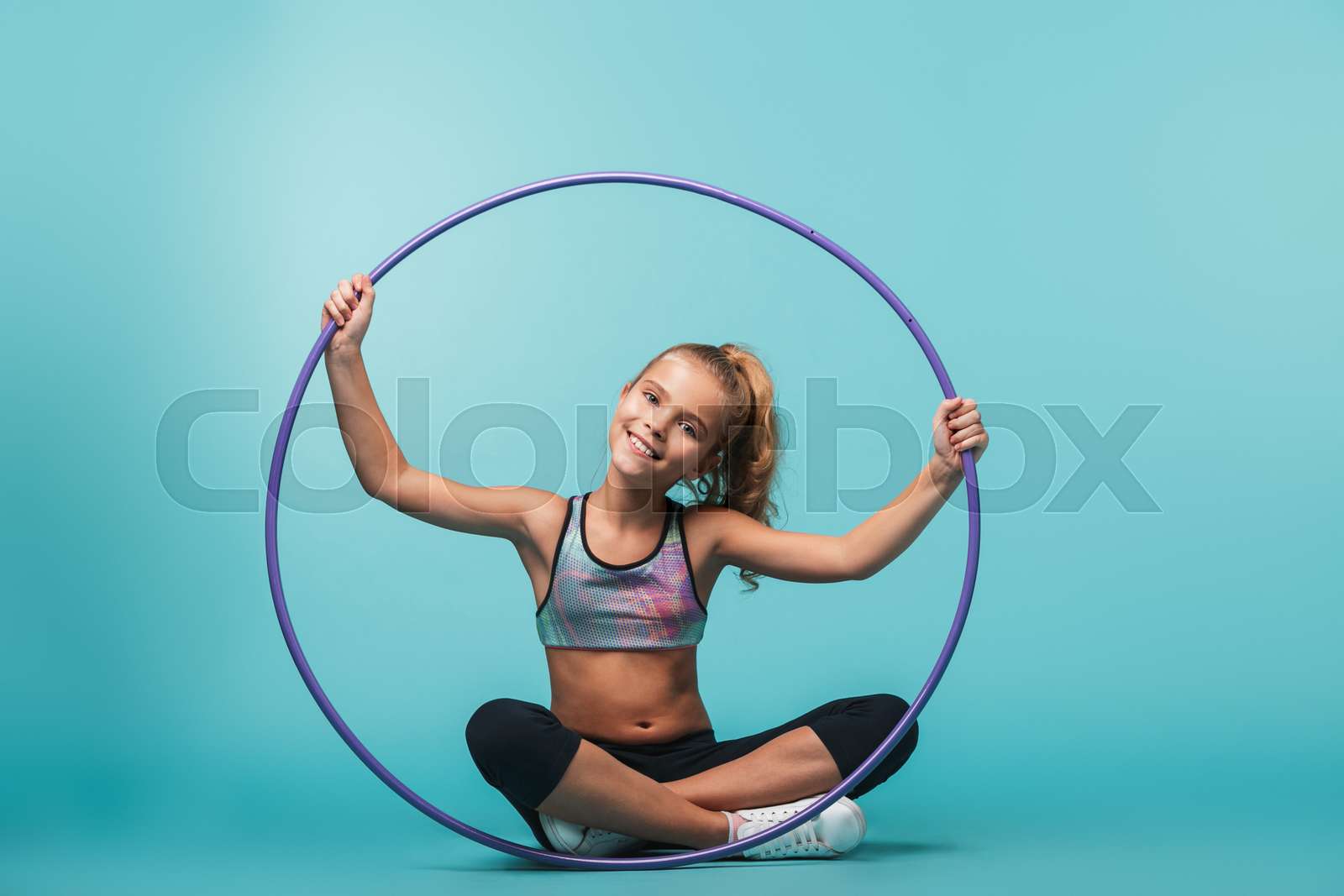 Cheerful little sports girl doing exercises with a hula hoop | Stock ...