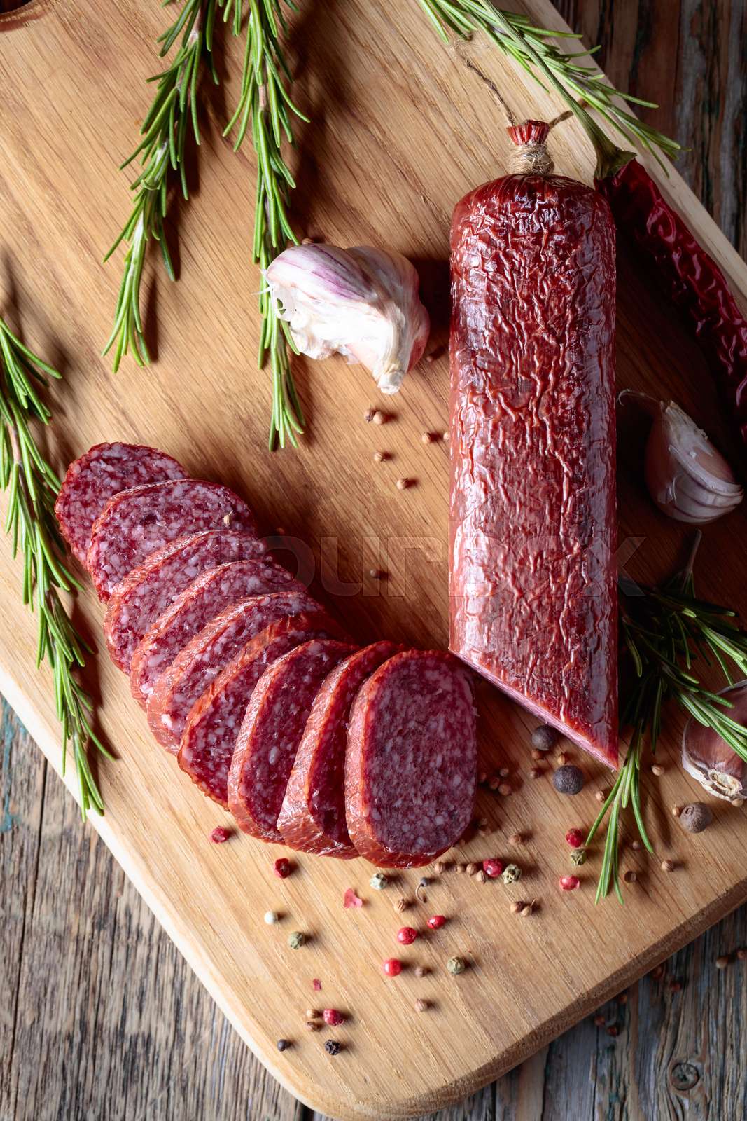 Smoked salami on a old wooden table. | Stock image | Colourbox