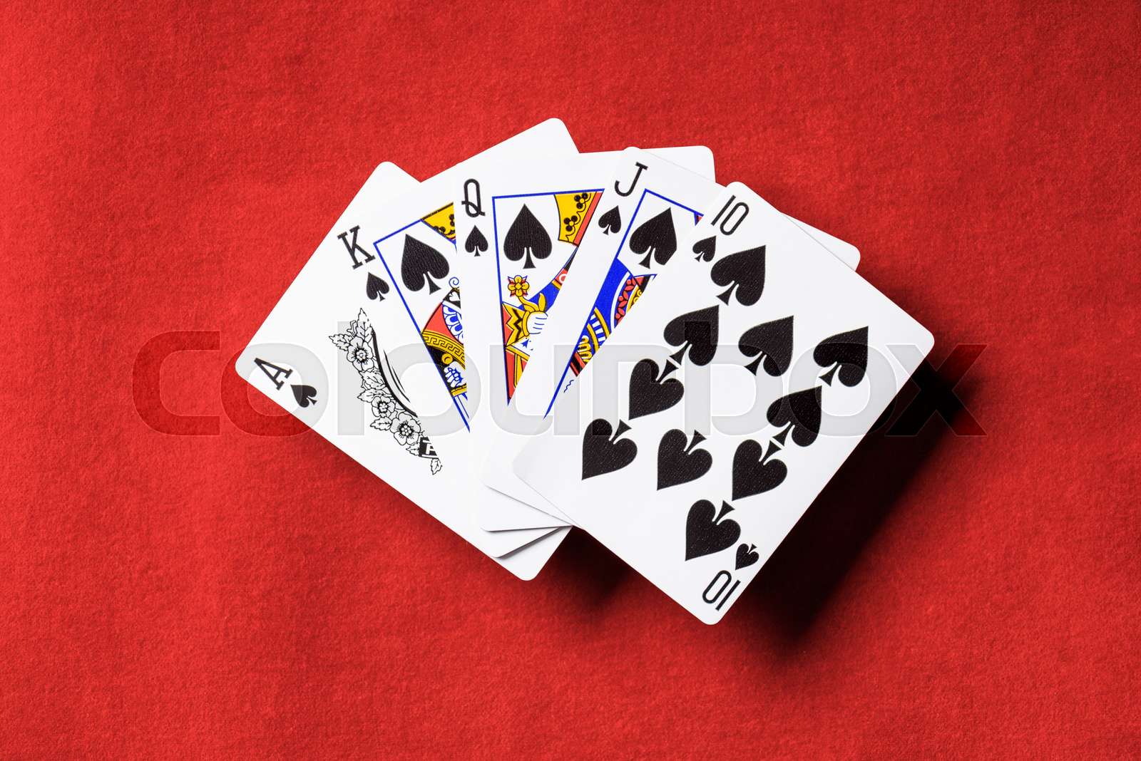 top view of red poker table and unfolded playing cards with spades suit ...