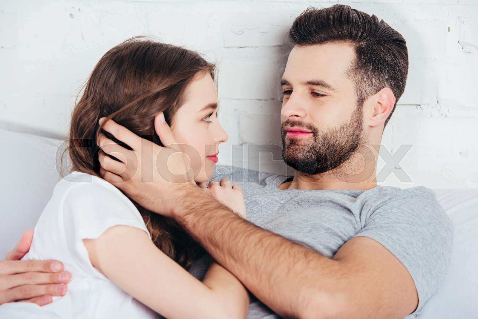 adult loving girl gentle looking in eyes of man in bed | Stock image ...