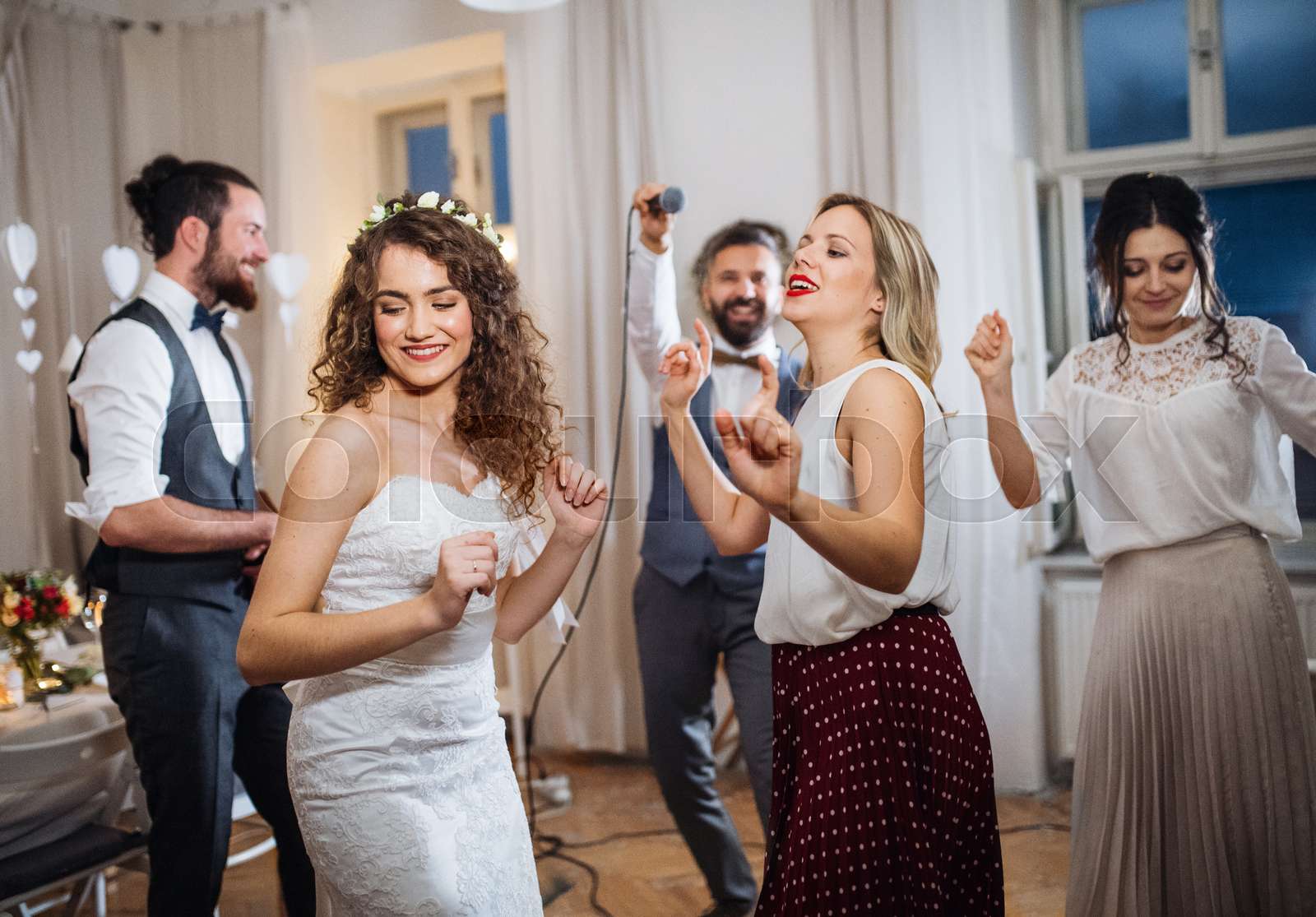 A young bride with other guests dancing on a wedding reception. | Stock ...