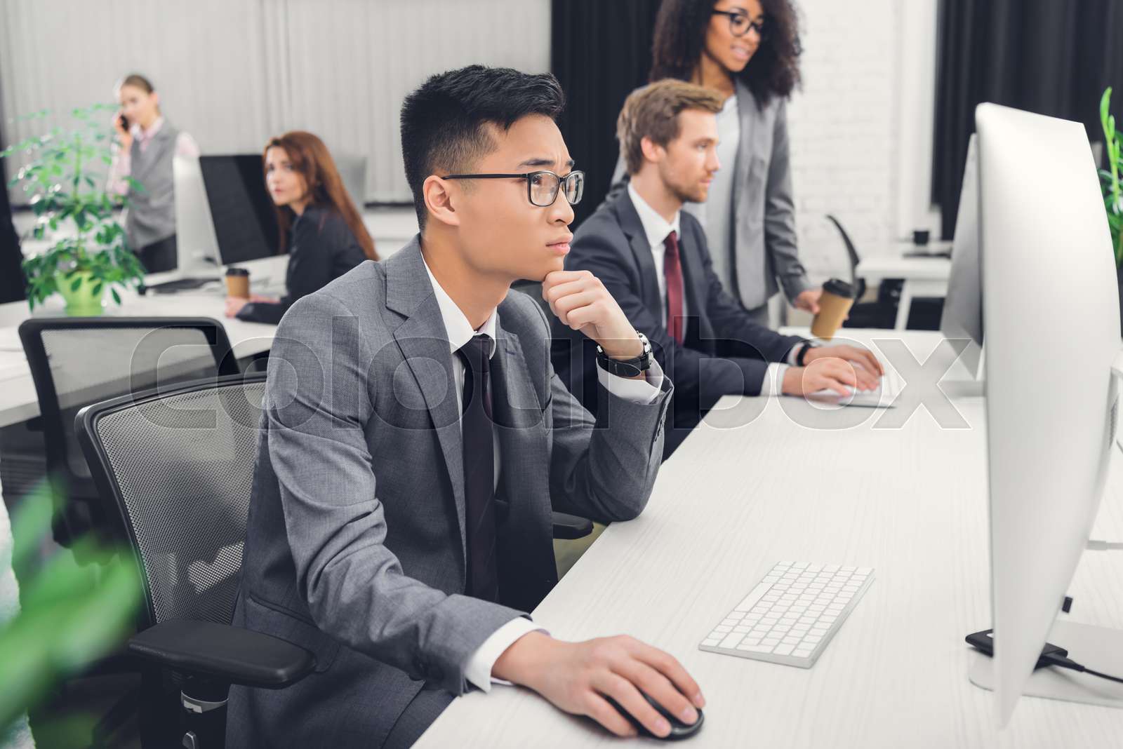 side view of focused business people using desktop computers in office ...