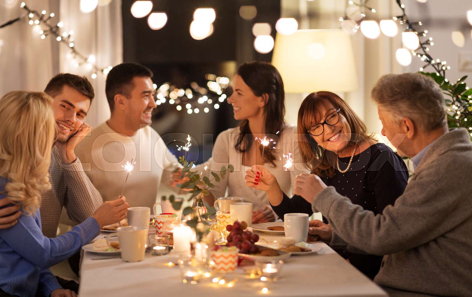 family with sparklers having dinner party at home | Stock image | Colourbox