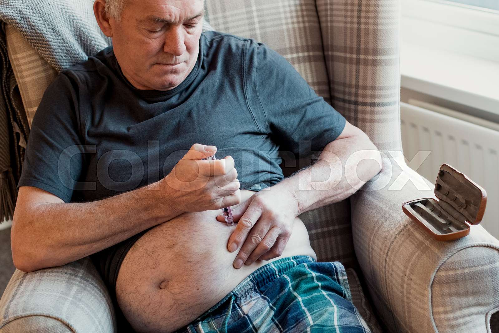 Diabetic Man Injecting Insulin at Home | Stock image | Colourbox