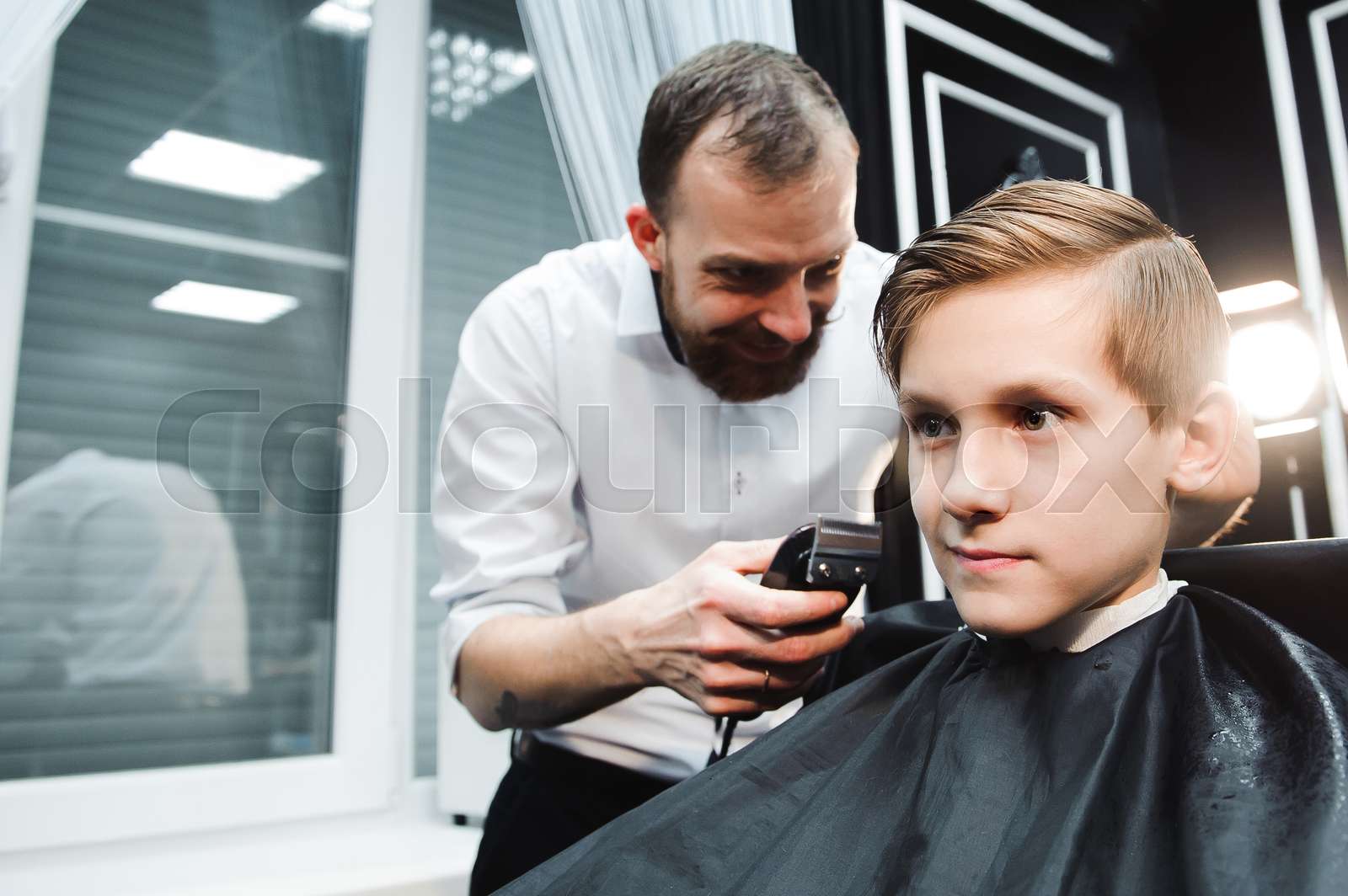 cute young boy getting a haircut in a salon | Stock image | Colourbox