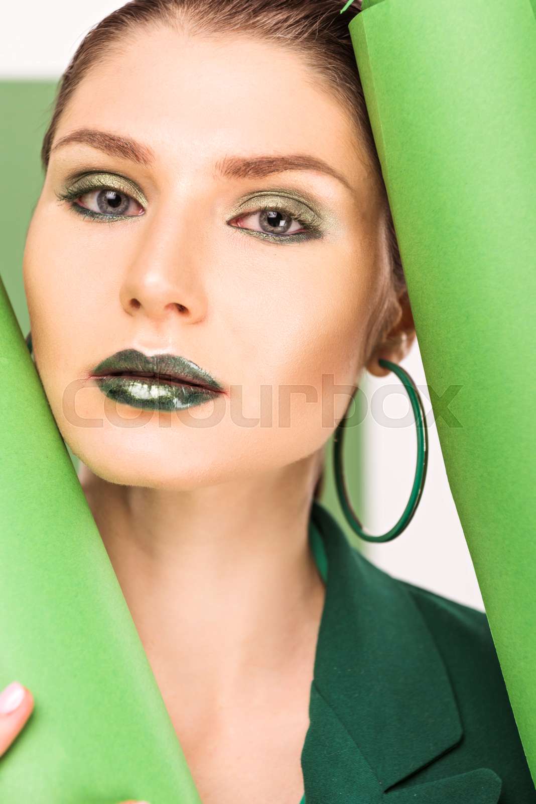 beautiful stylish woman looking at camera and posing with sea green ...