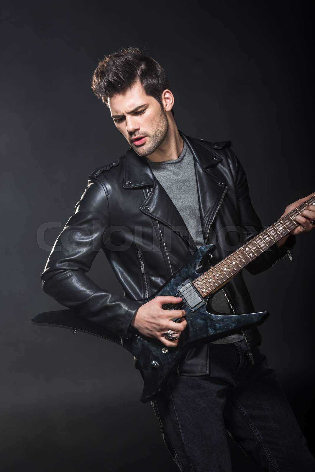 handsome rocker in leather jacket playing electric guitar isolated on ...