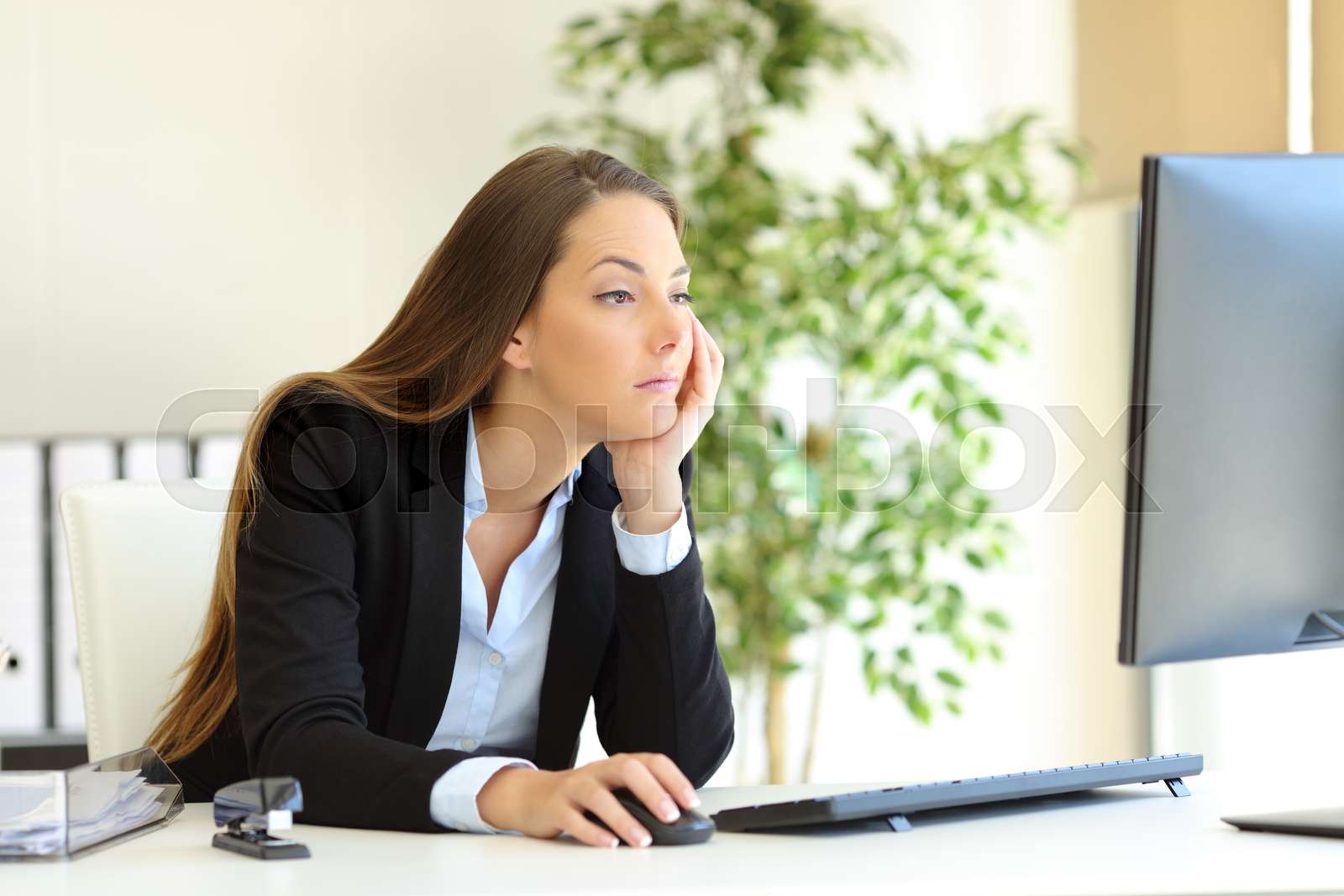 Confused office worker checking computer content | Stock image | Colourbox