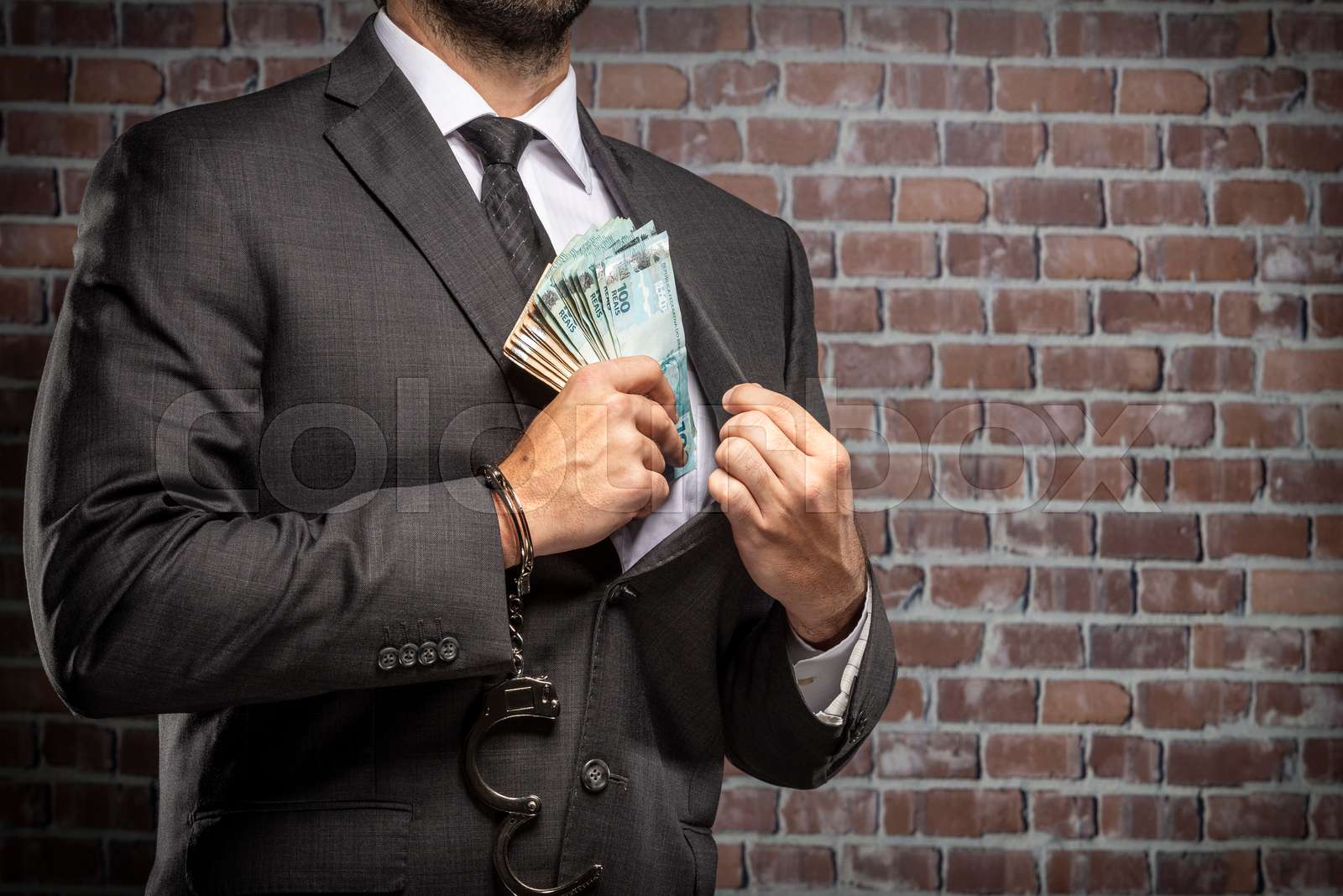 Corrupt man holding bills of money | Stock image | Colourbox