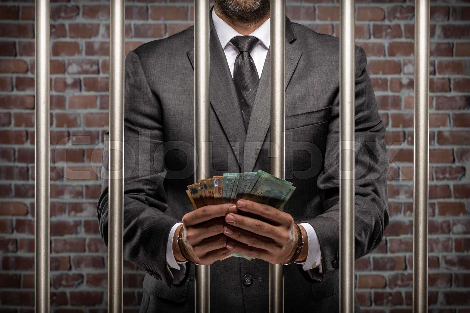 Corrupt man holding bills of money | Stock image | Colourbox