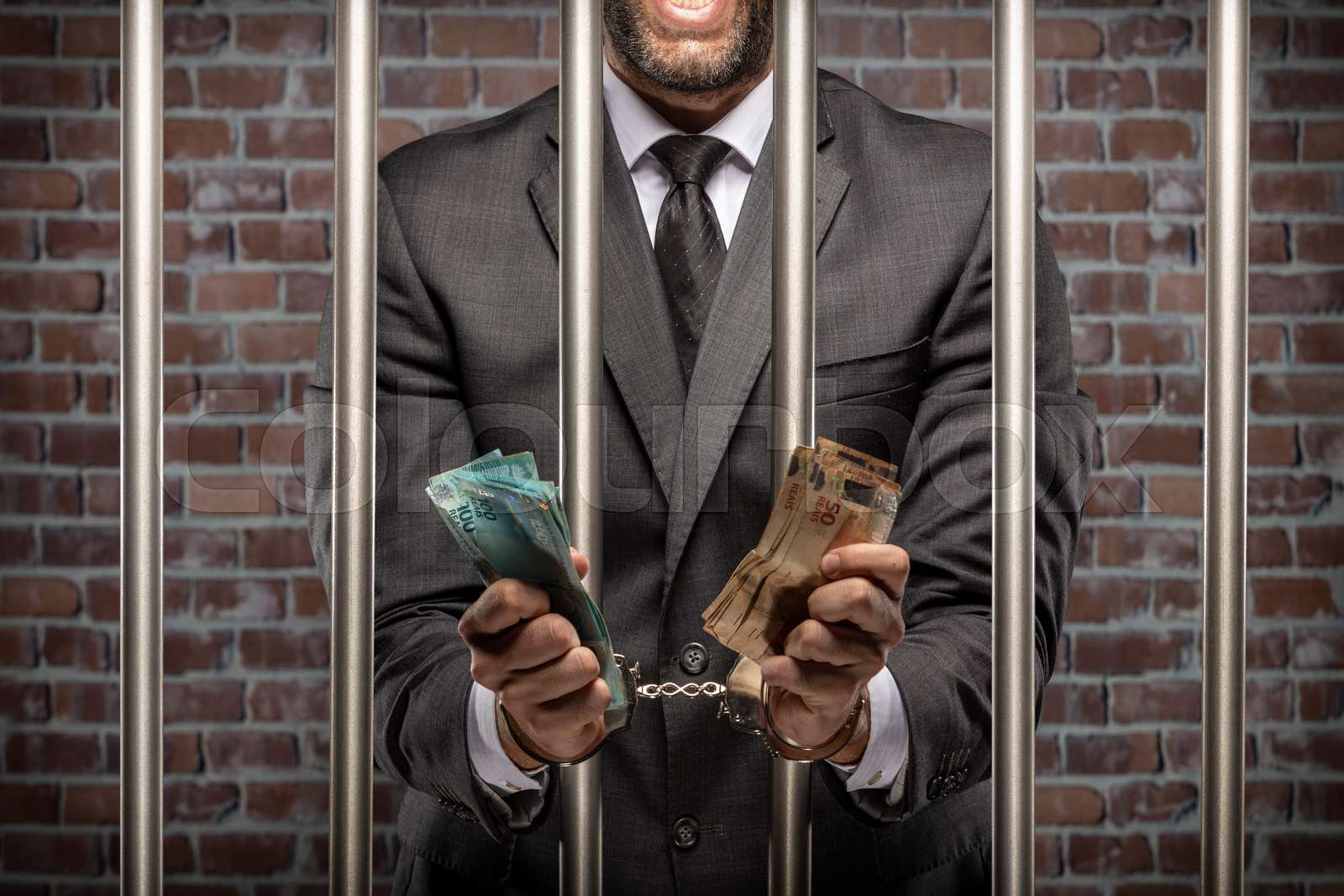 Corrupt man holding bills of money | Stock image | Colourbox