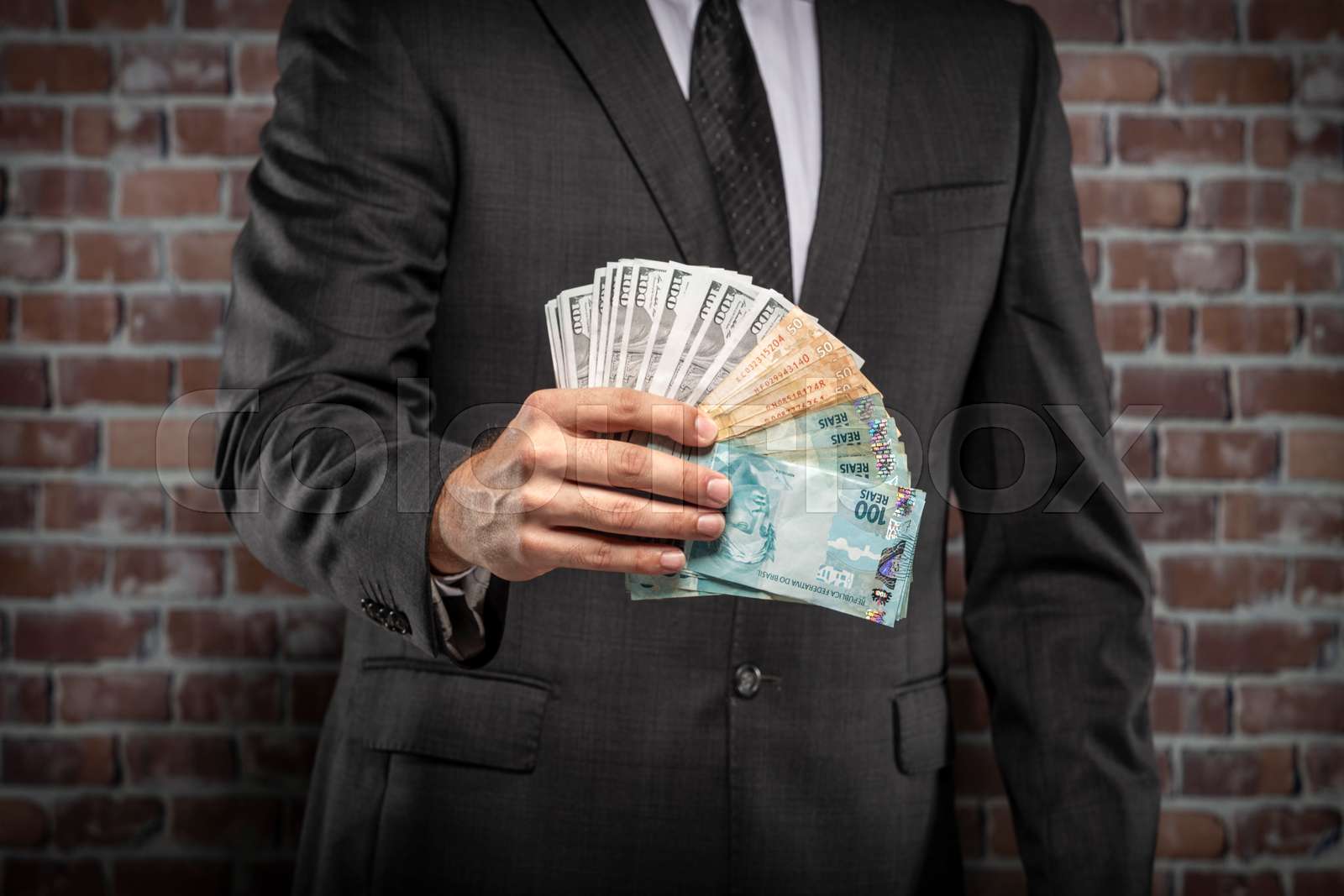 Corrupt man holding bills of money | Stock image | Colourbox