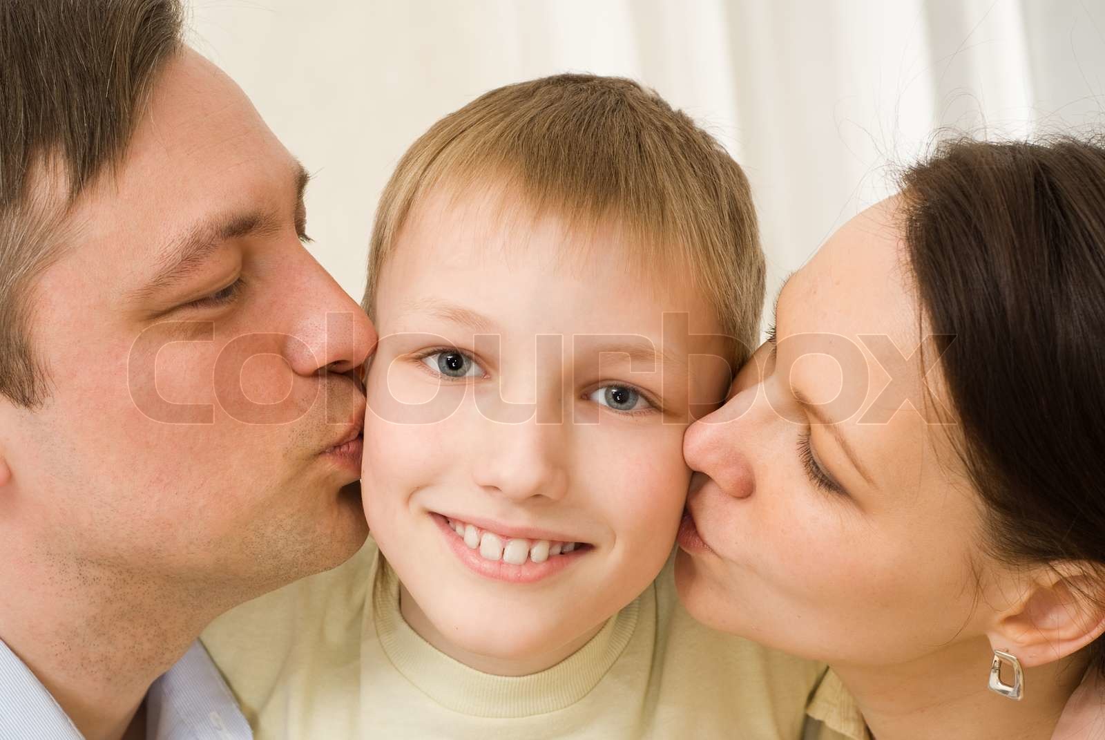 parents kissing her child | Stock image | Colourbox