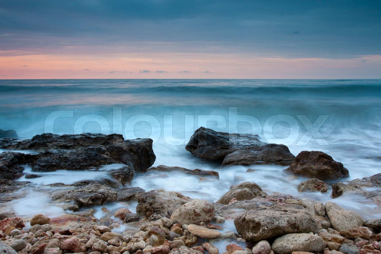 Beautiful rocky sea beach at the sunset | Stock image | Colourbox