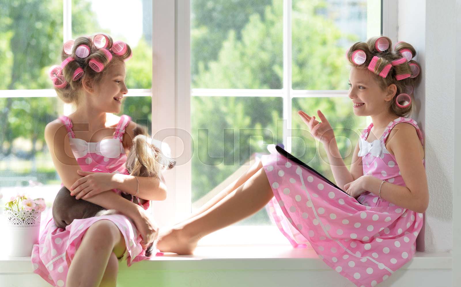 Portrait of cute tweenie girls with hair curlers sitting | Stock image ...