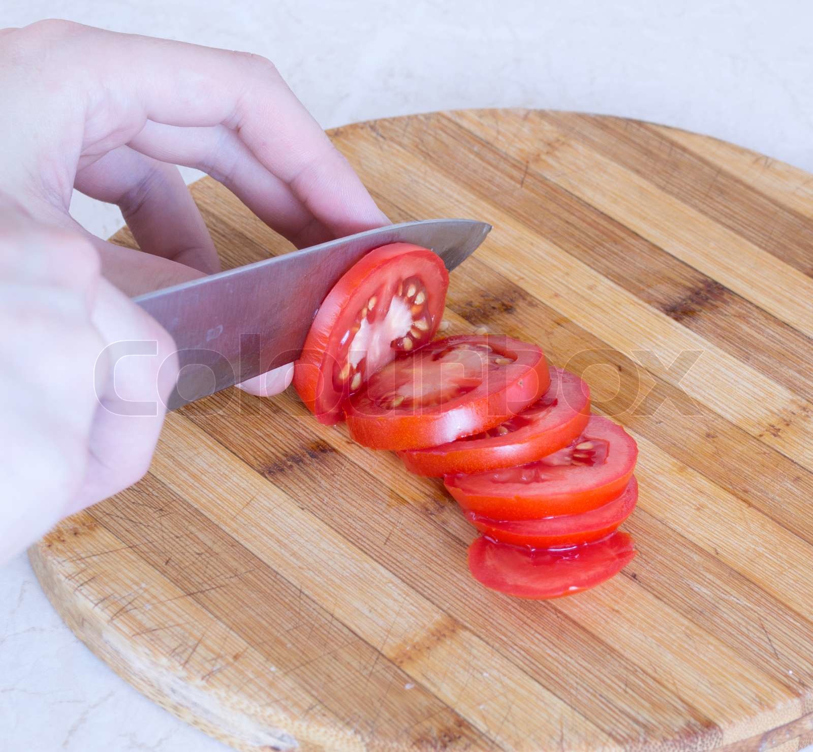 Tomaten in Scheiben geschnitten mit einem Messer auf einem Brett ...