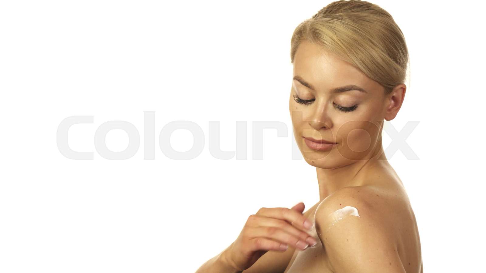 Beautiful girl is rubing cream into her body | Stock image | Colourbox