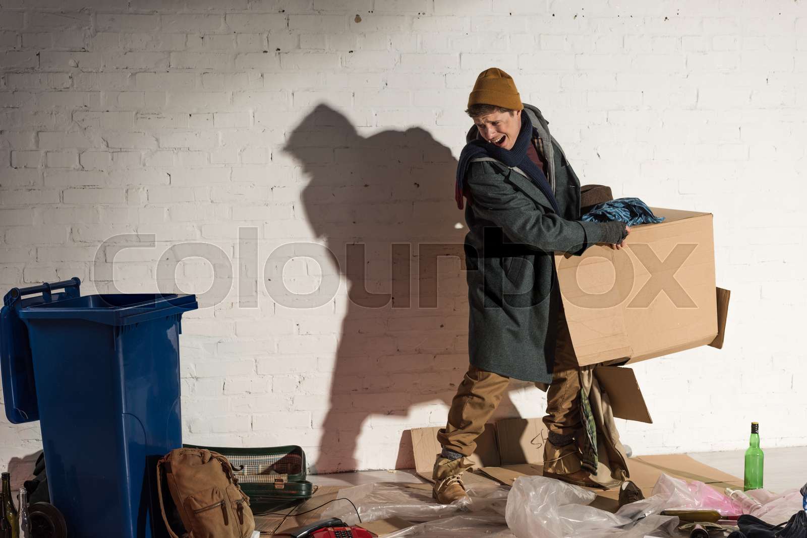 angry homeless man holding cardboard box with garbage | Stock image ...