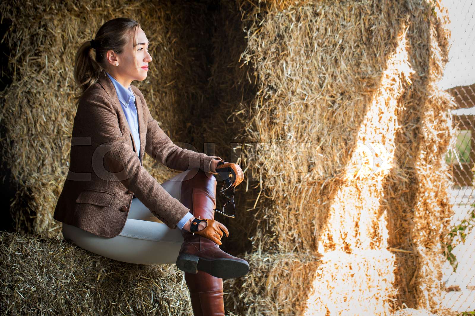 woman sitting in a barn with hay | Stock image | Colourbox