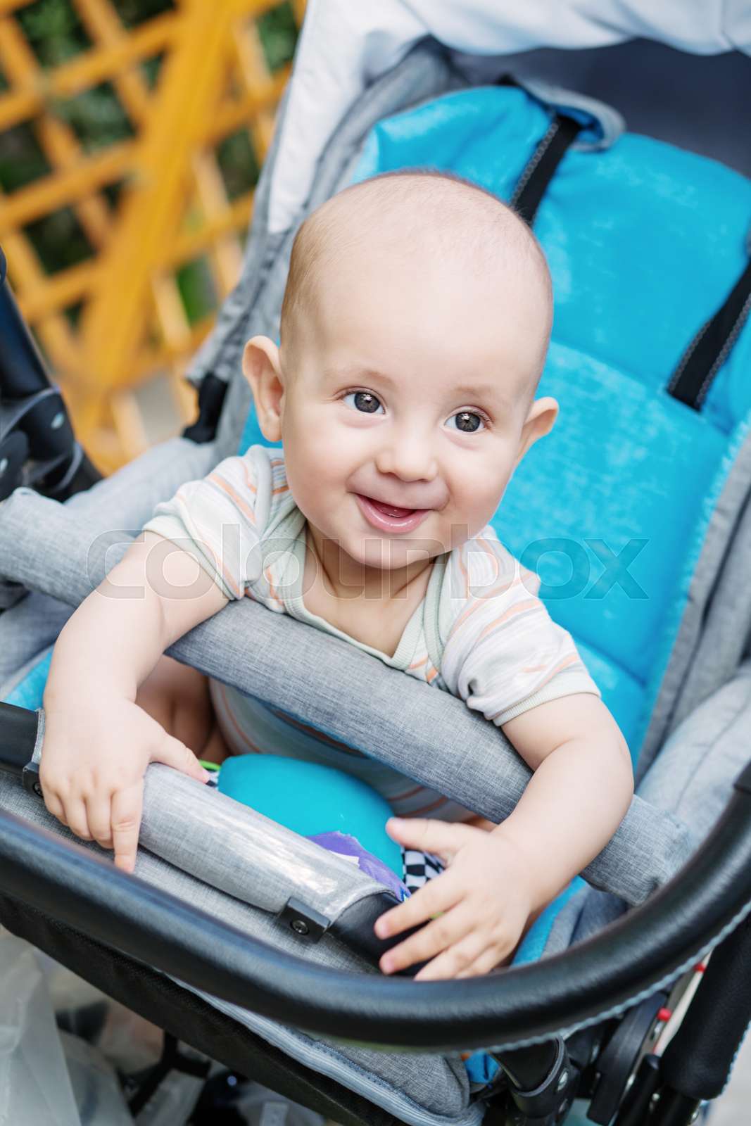 happy baby boy sitting in a stroller | Stock image | Colourbox