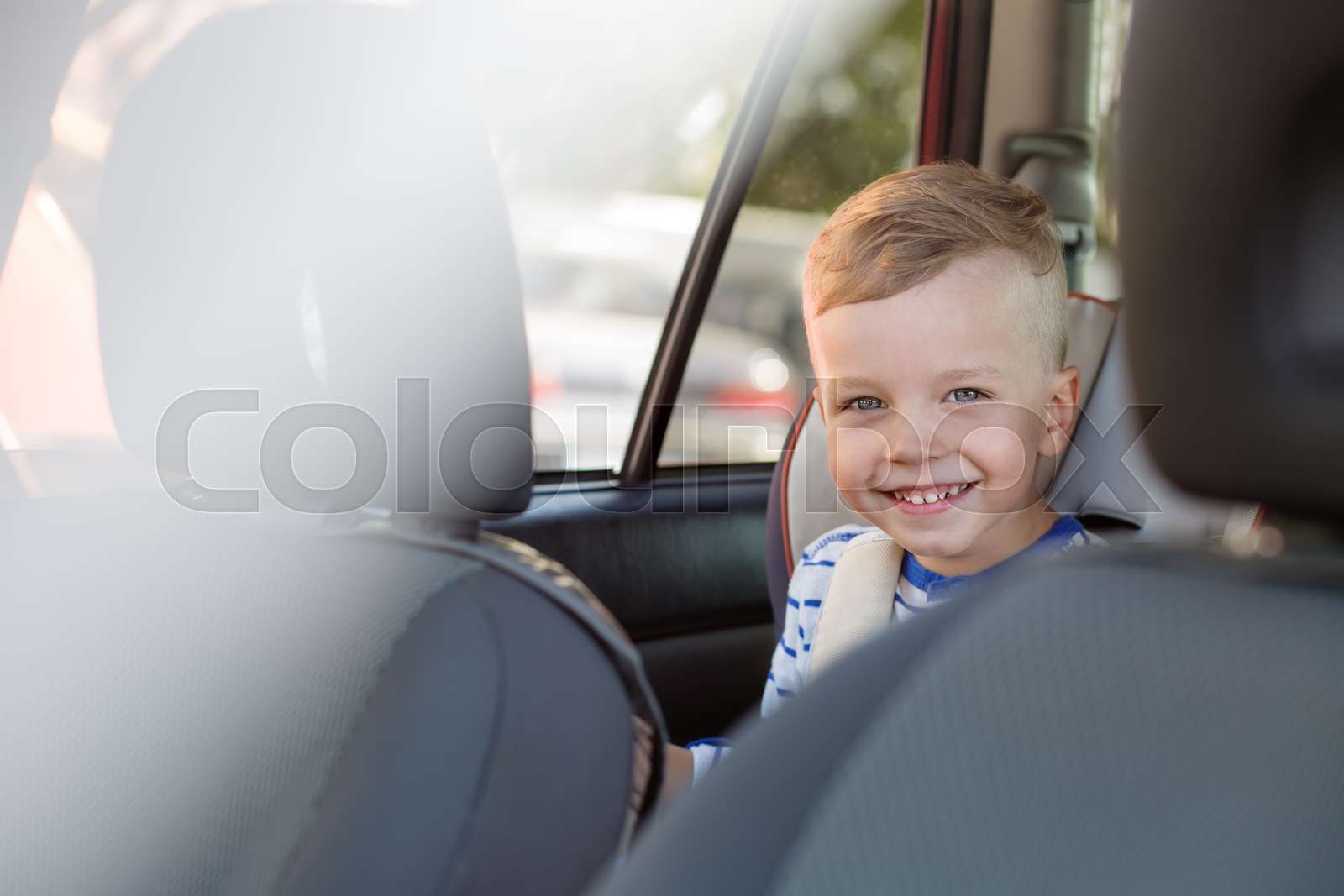 portrait happy toddler boy sitting in the car | Stock image | Colourbox