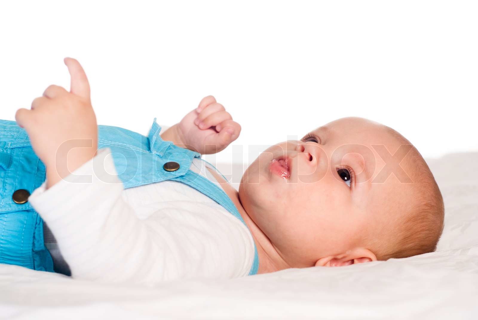 baby lying on bed | Stock image | Colourbox