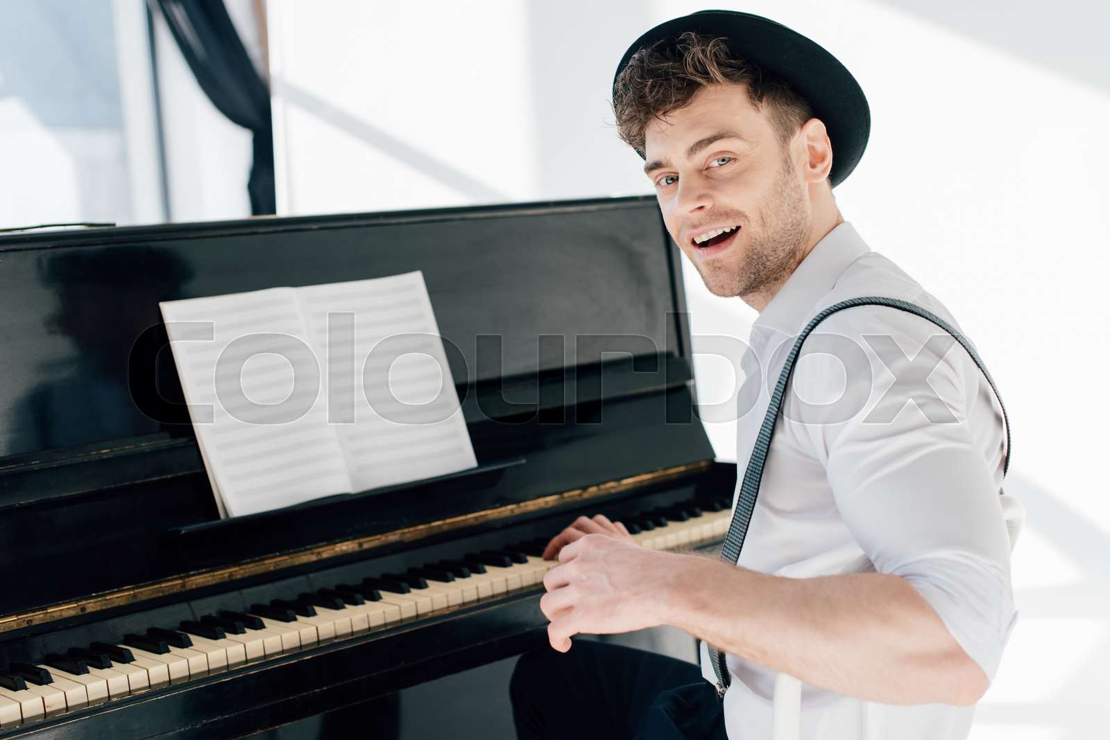 smiling pianist sitting by piano and looking at camera | Stock image ...