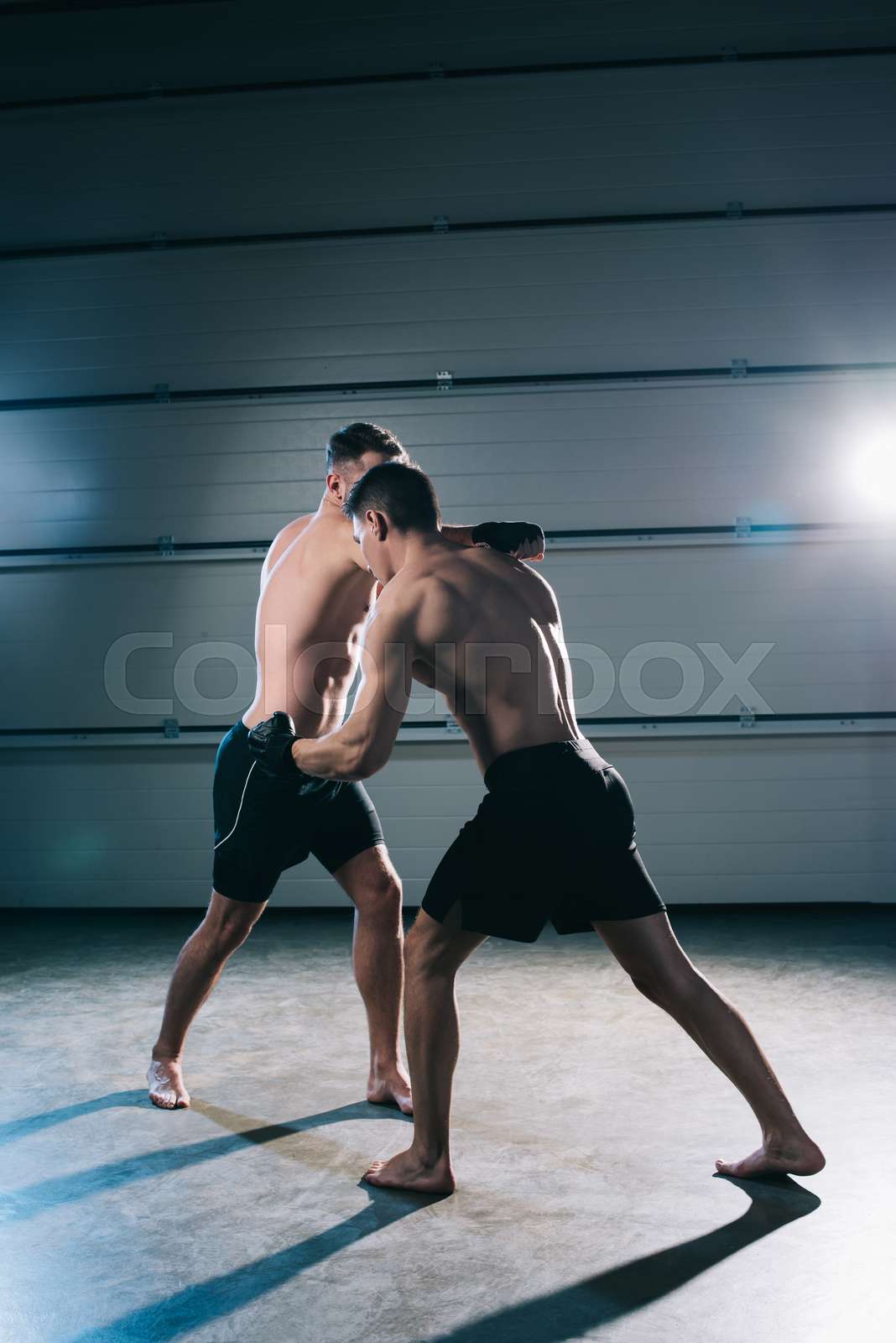 strong shirtless mma sportsmen fighting while man punching with arm ...