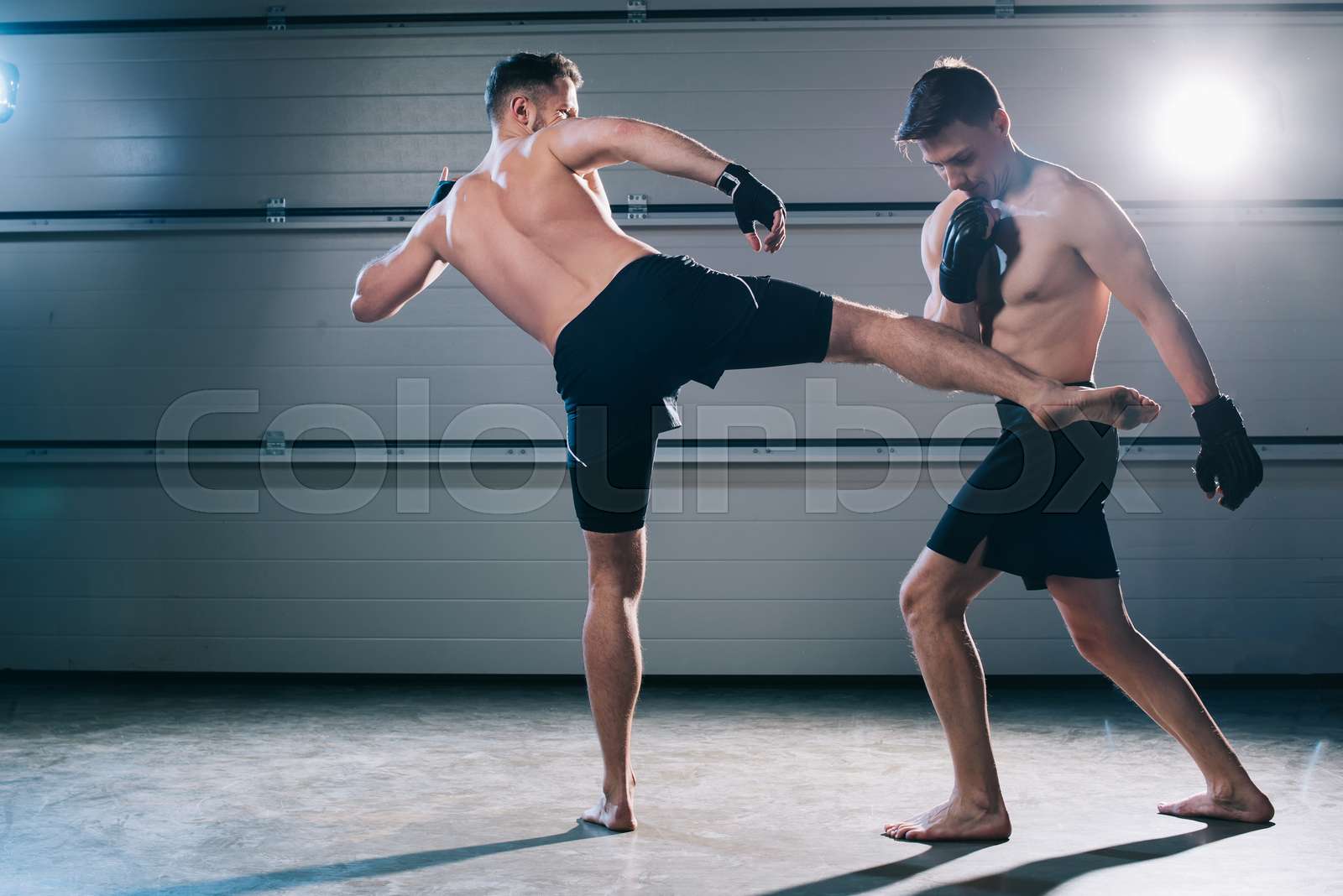back view of barefoot mma fighter kicking opponent with leg | Stock ...