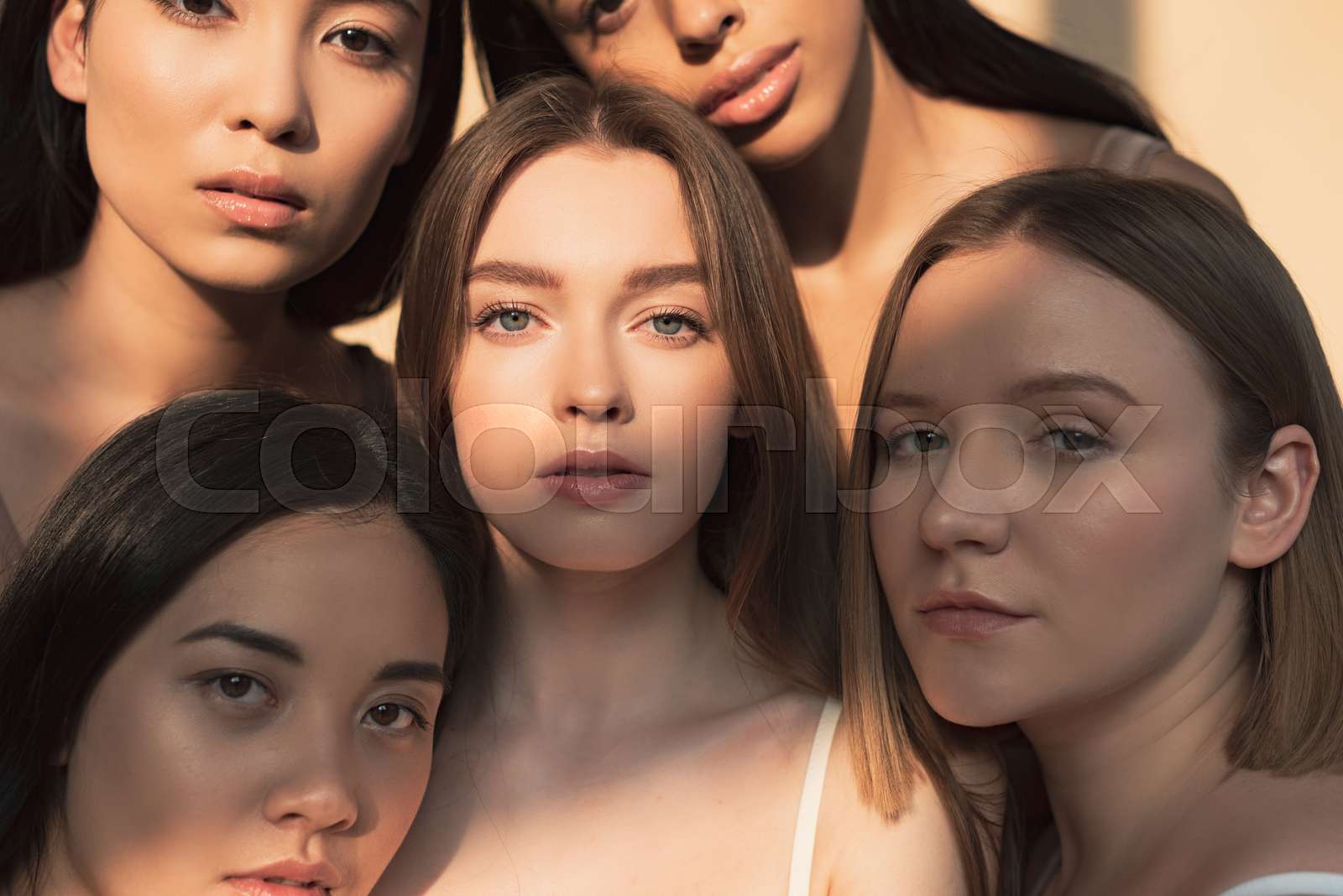 five beautiful multicultural girls looking at camera in sunlight ...