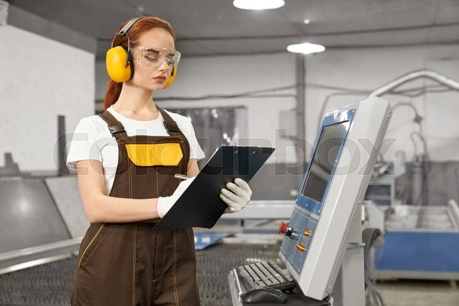 Engineer holding folder, operating computerized machine. | Stock image ...