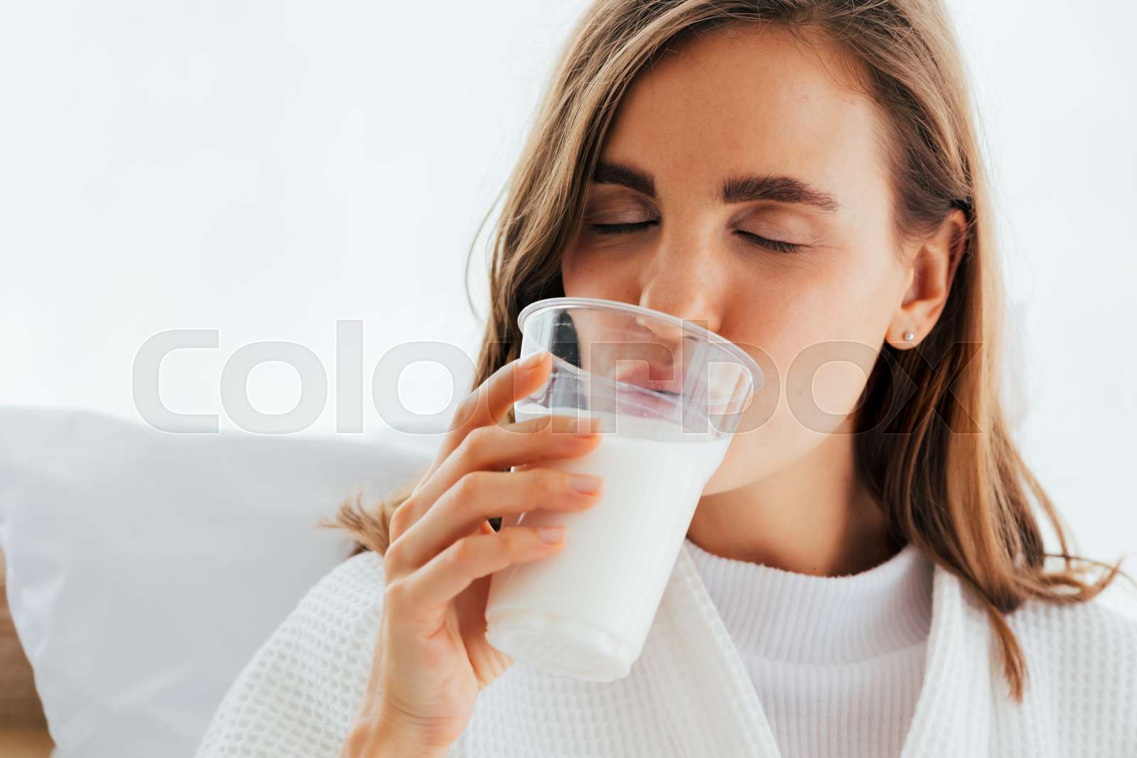 Young woman drinking milk from cup | Stock image | Colourbox