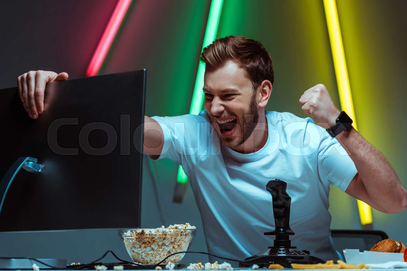 handsome and happy man holding computer monitor and showing yes gesture ...
