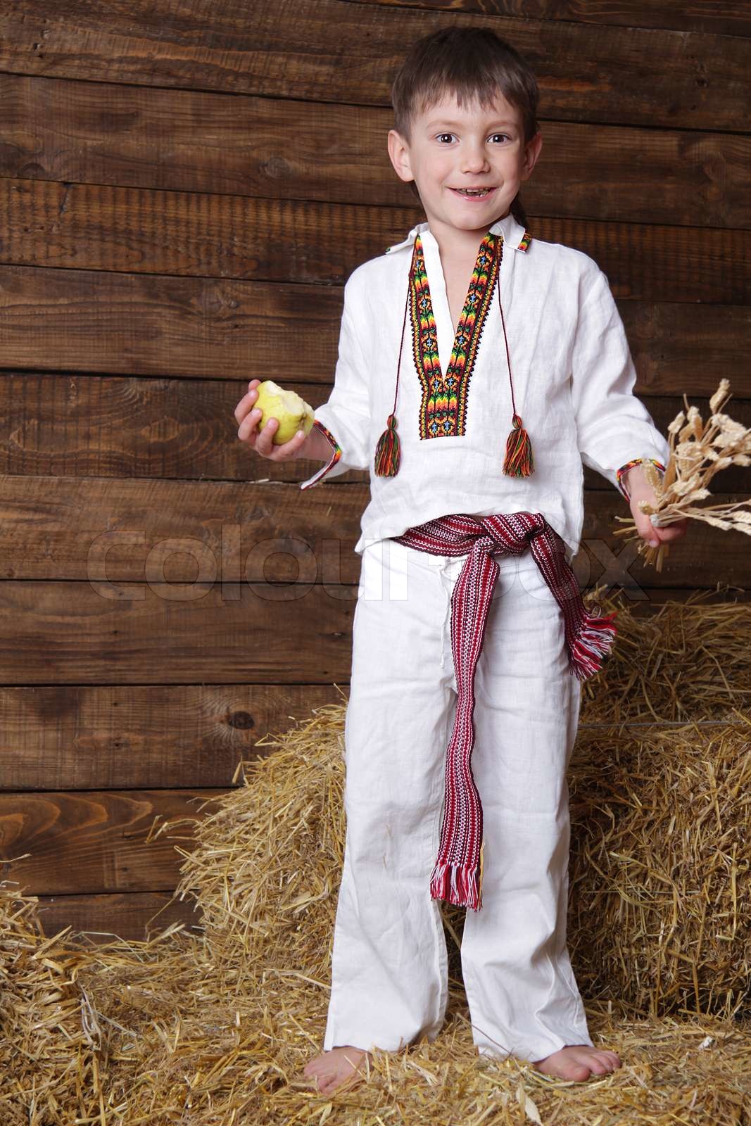 happy young boy in traditional eastern european clothes on hayloft ...