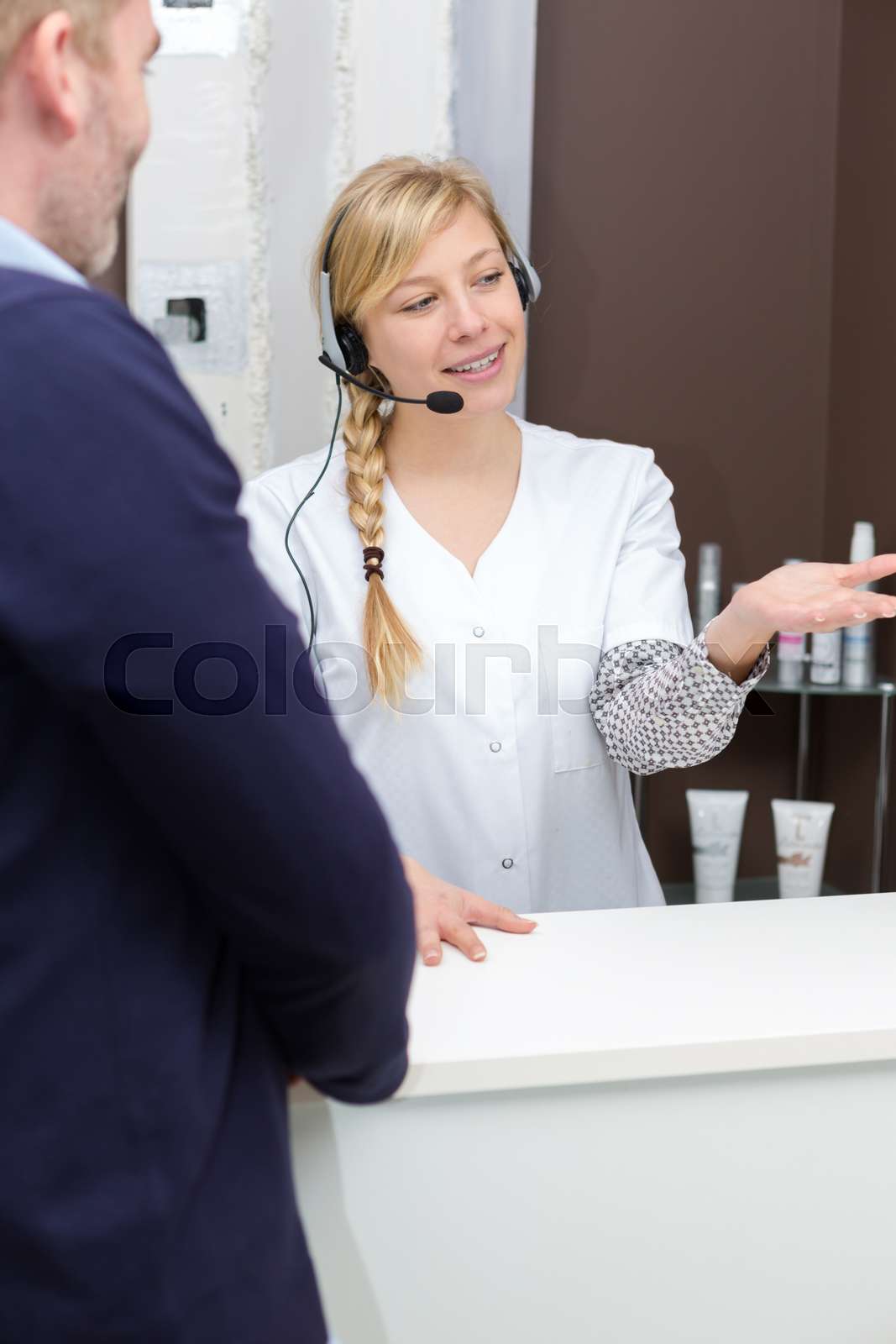 young female receptionist talking to client | Stock image | Colourbox