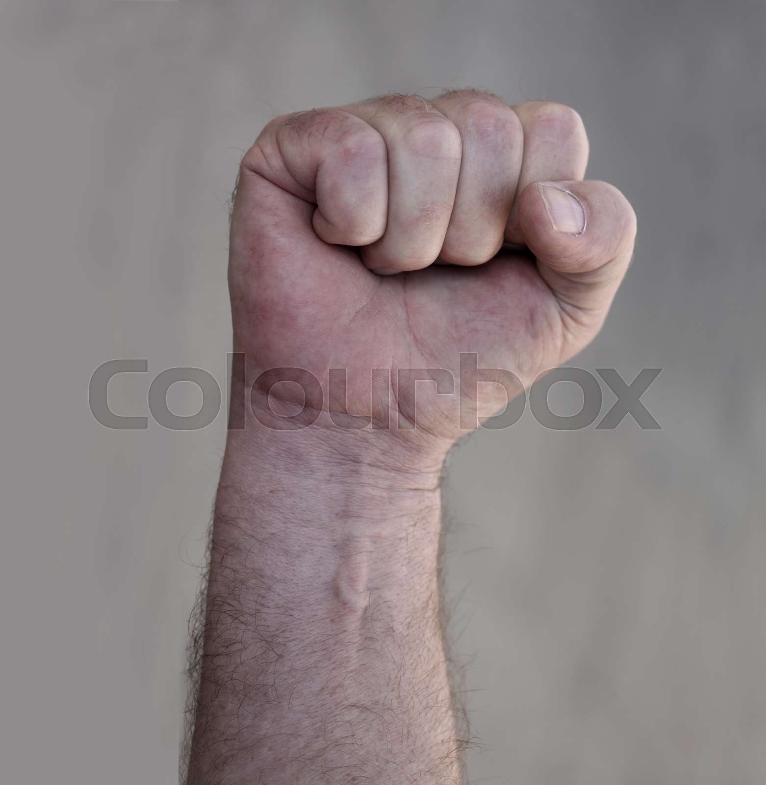 Raised clenched fist of adult male in the air as a threat of fighting ...