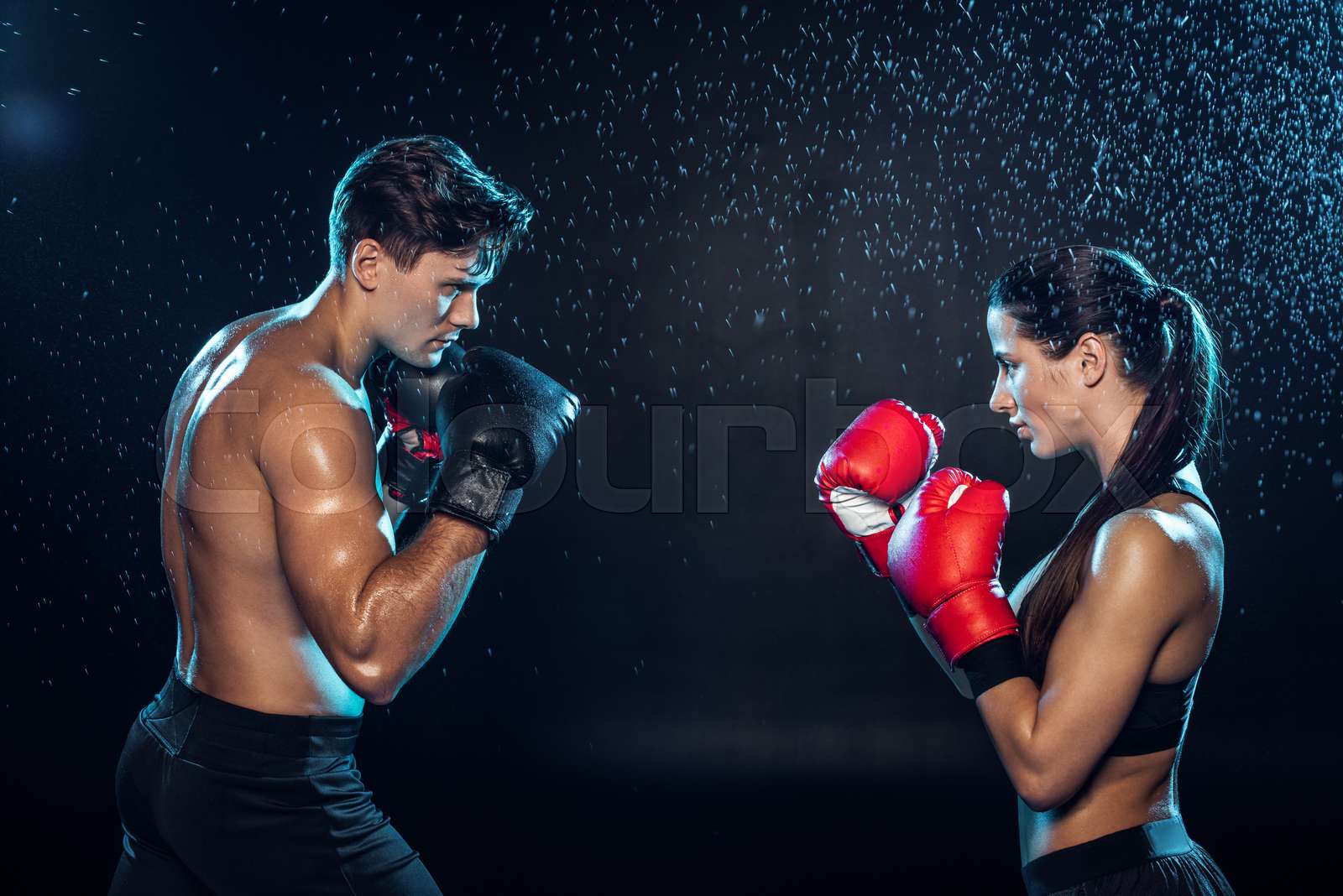 Side view of two boxers in boxing gloves training together under water ...