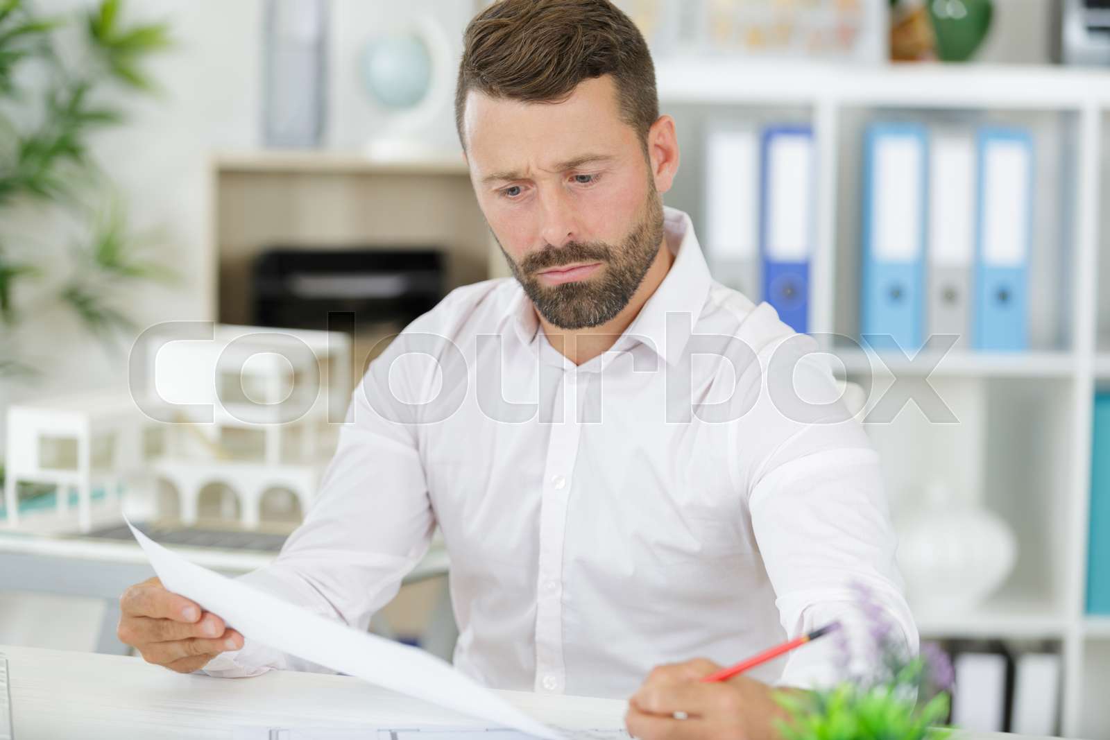 man sat at table with pen and paper | Stock image | Colourbox