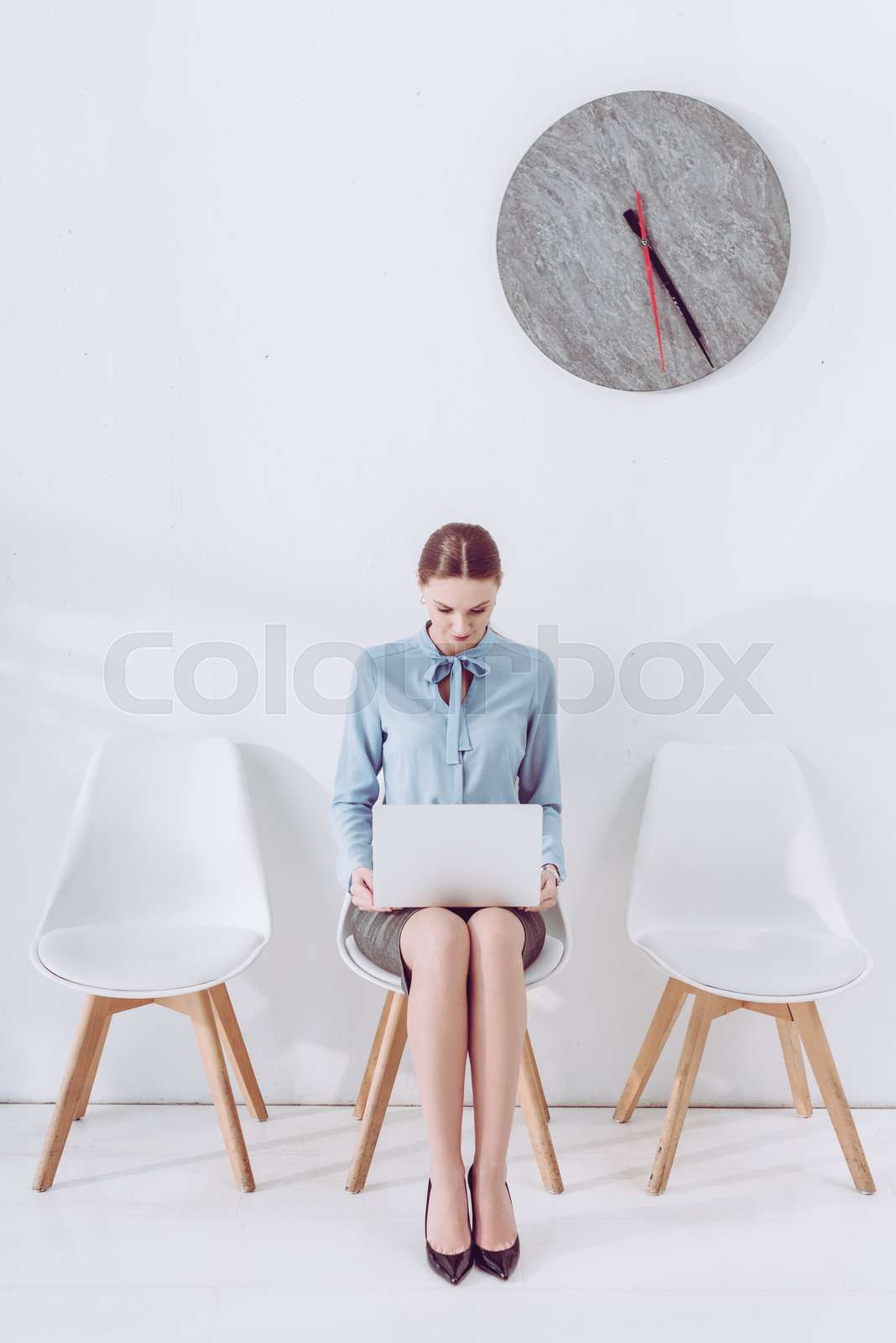 attractive employee sitting on chair and using laptop | Stock image ...