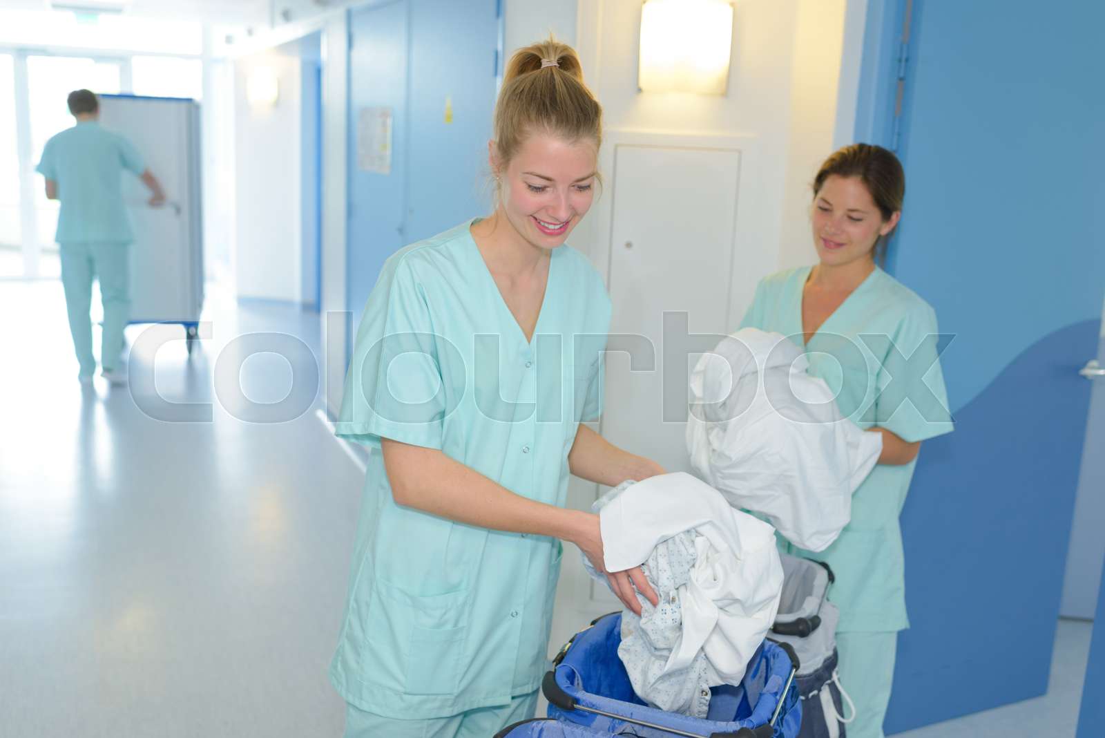 Auxiliary nurses collecting laundry | Stock image | Colourbox