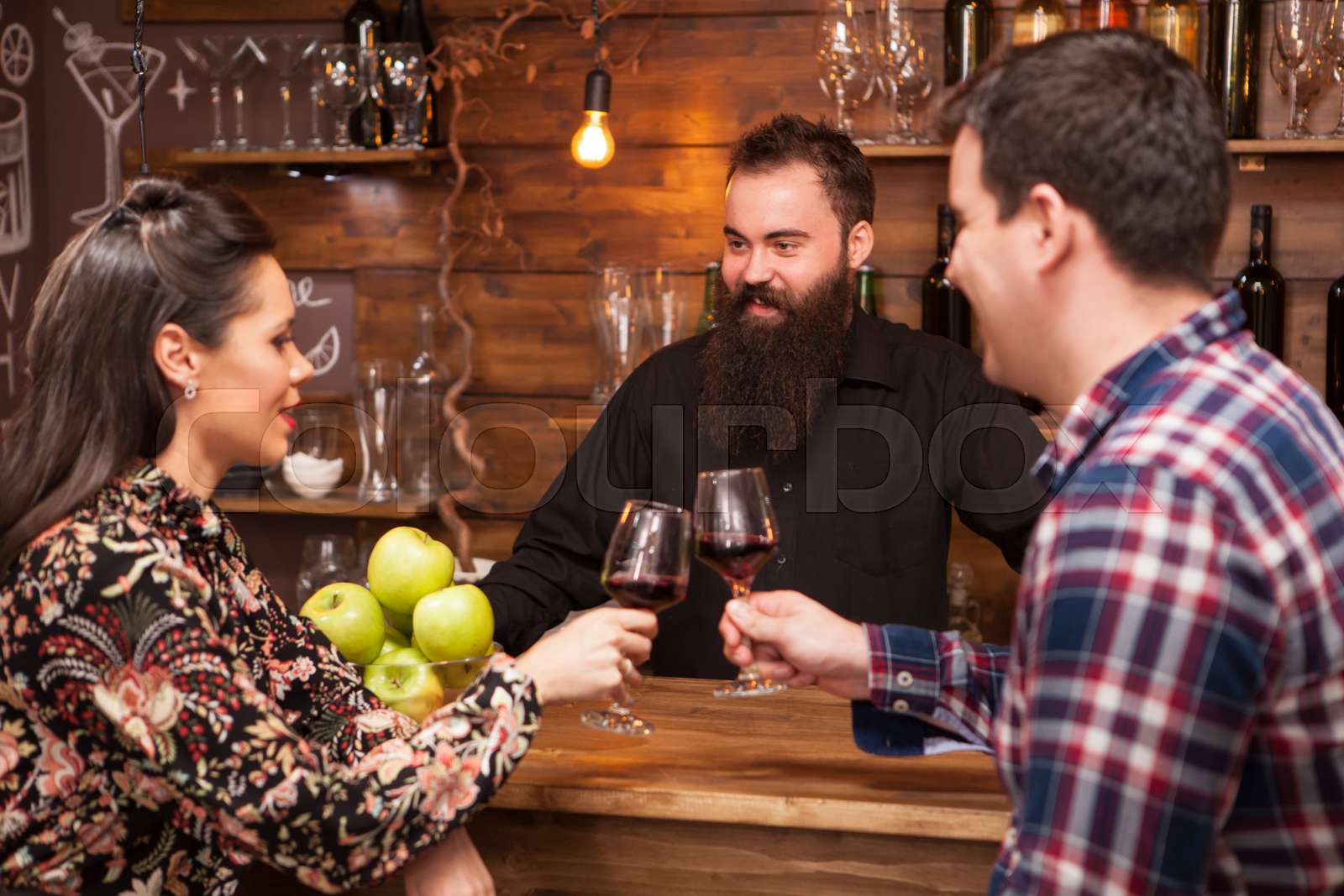 Couple talking to bartender behind bar counter in a cafe. | Stock image ...