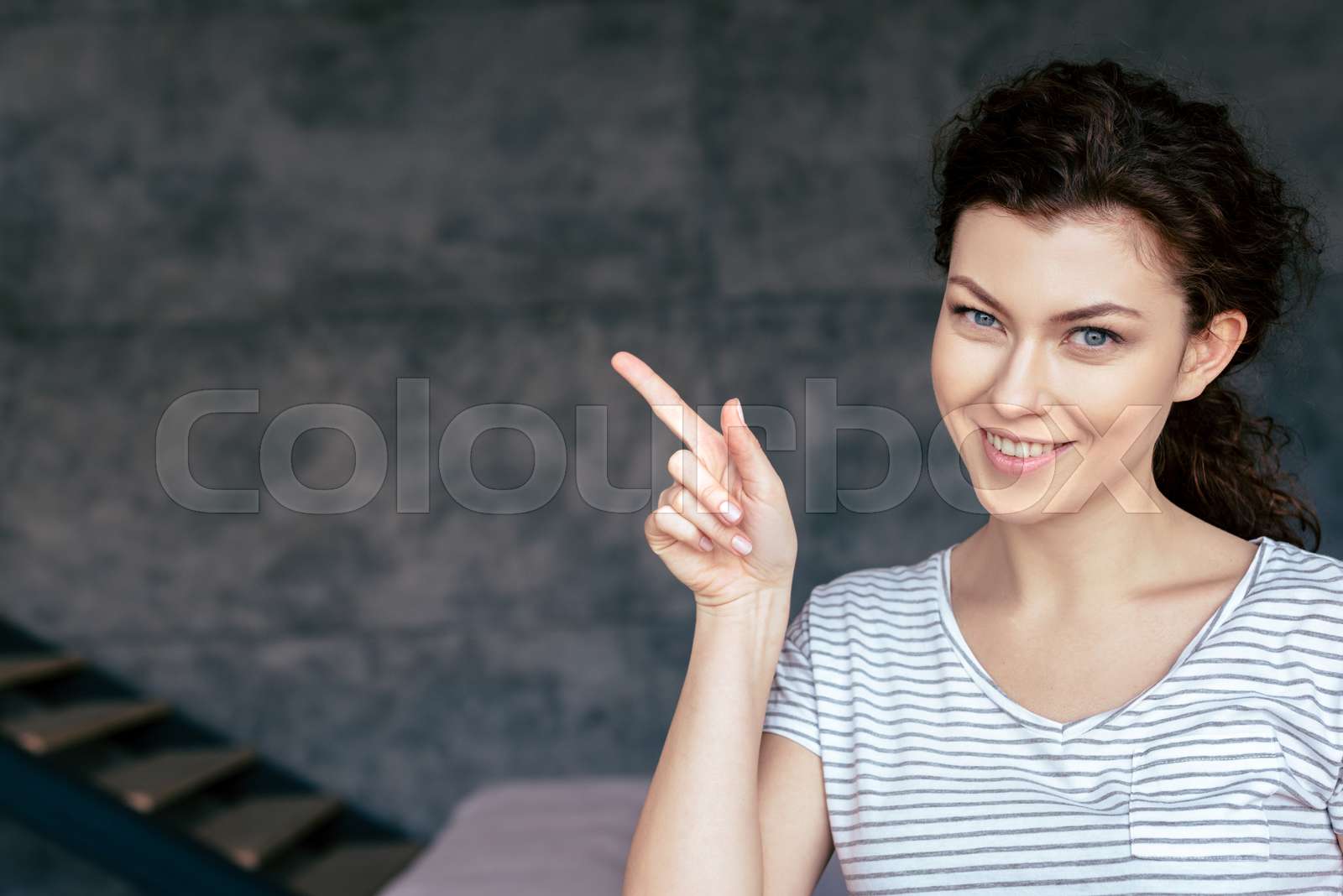 pretty smiling girl pointing with finger and looking at camera | Stock ...