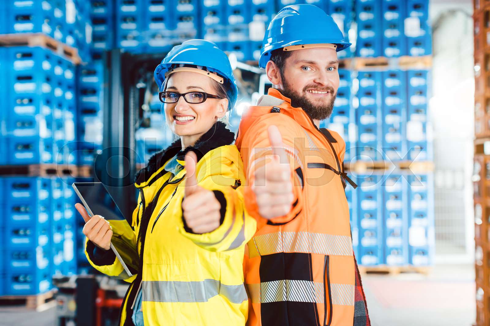 Workers in logistics distribution center showing thumbs-up | Stock ...