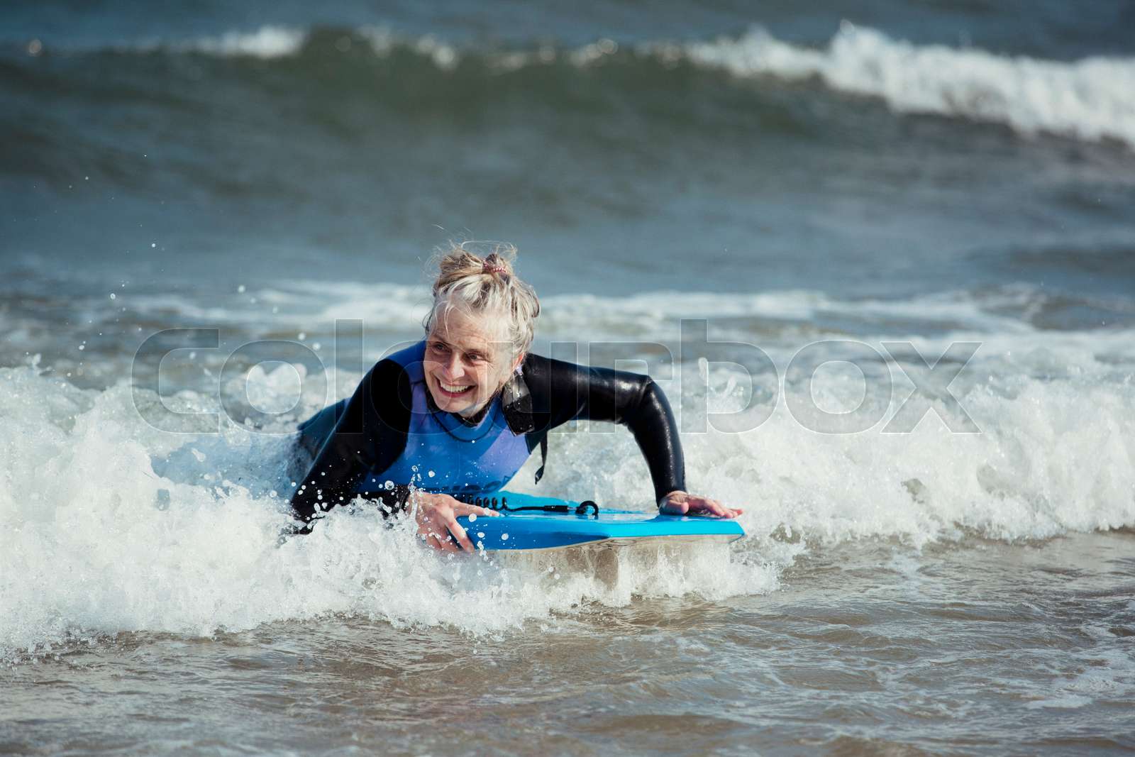Mature Woman Bodyboarding in the Sea | Stock image | Colourbox