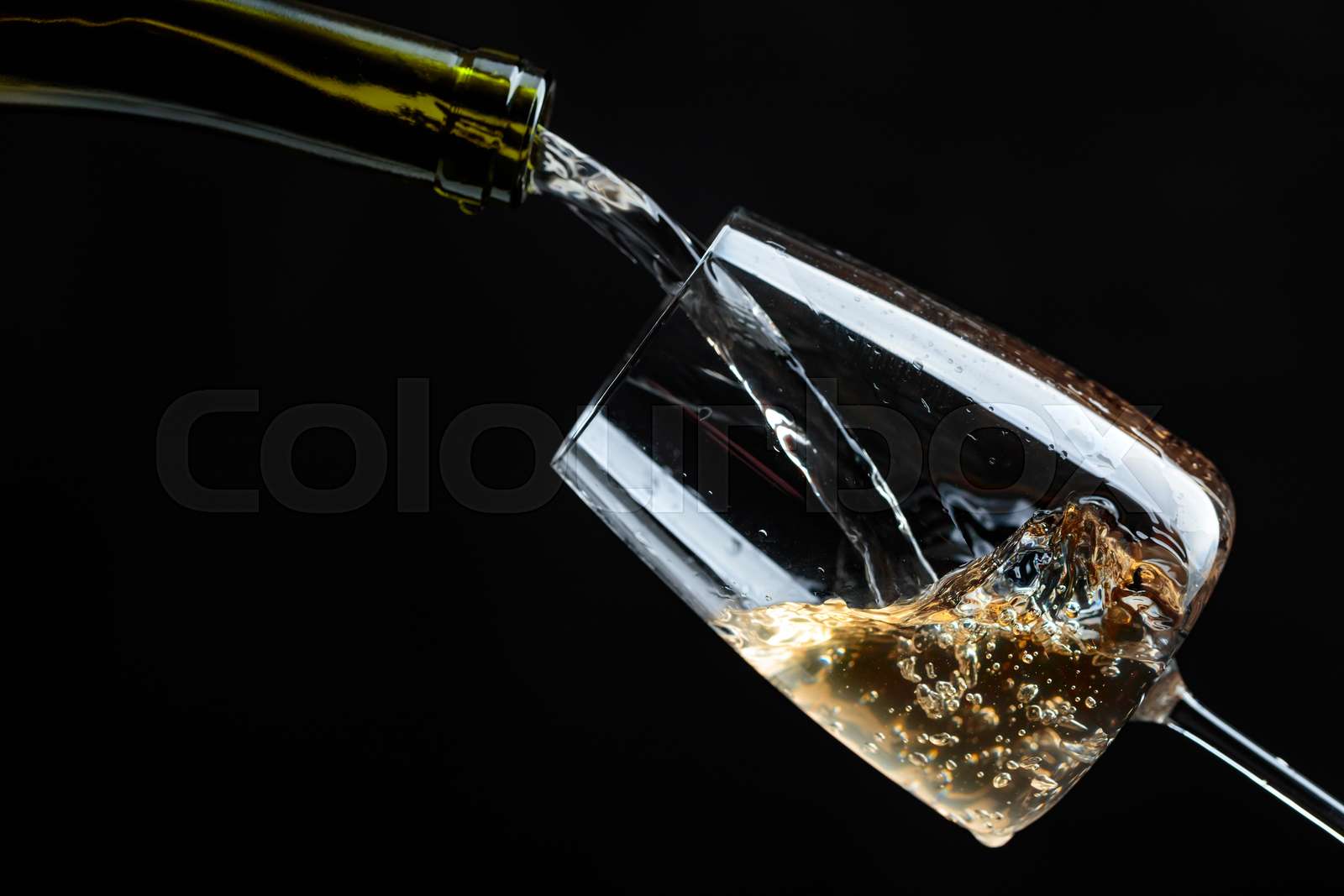 White wine being poured into wine glass. | Stock image | Colourbox
