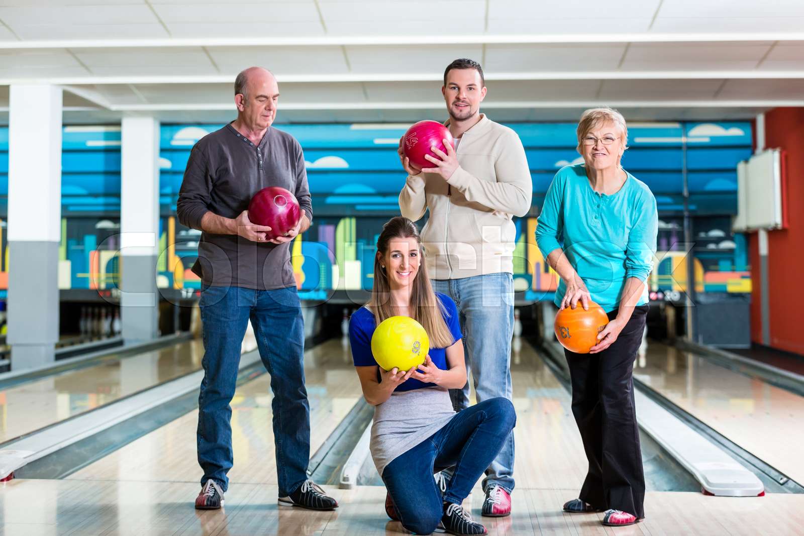 Smiling family holding bowling ball | Stock image | Colourbox