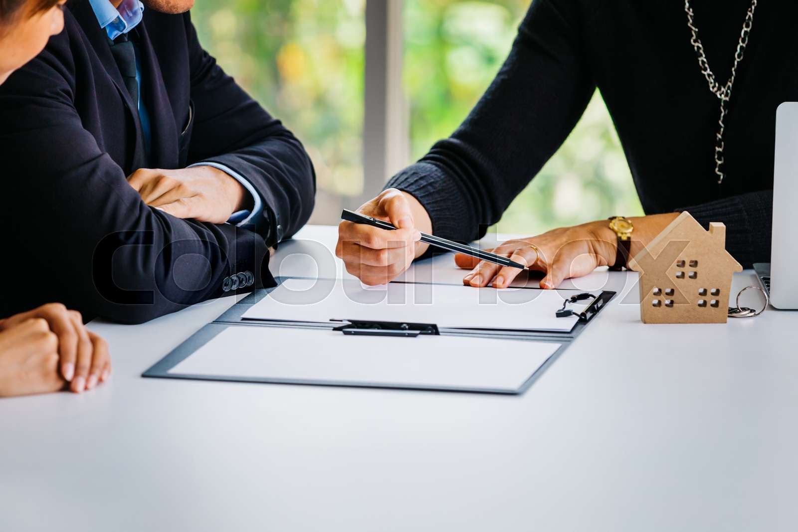 Couple signing contract paper with agent | Stock image | Colourbox